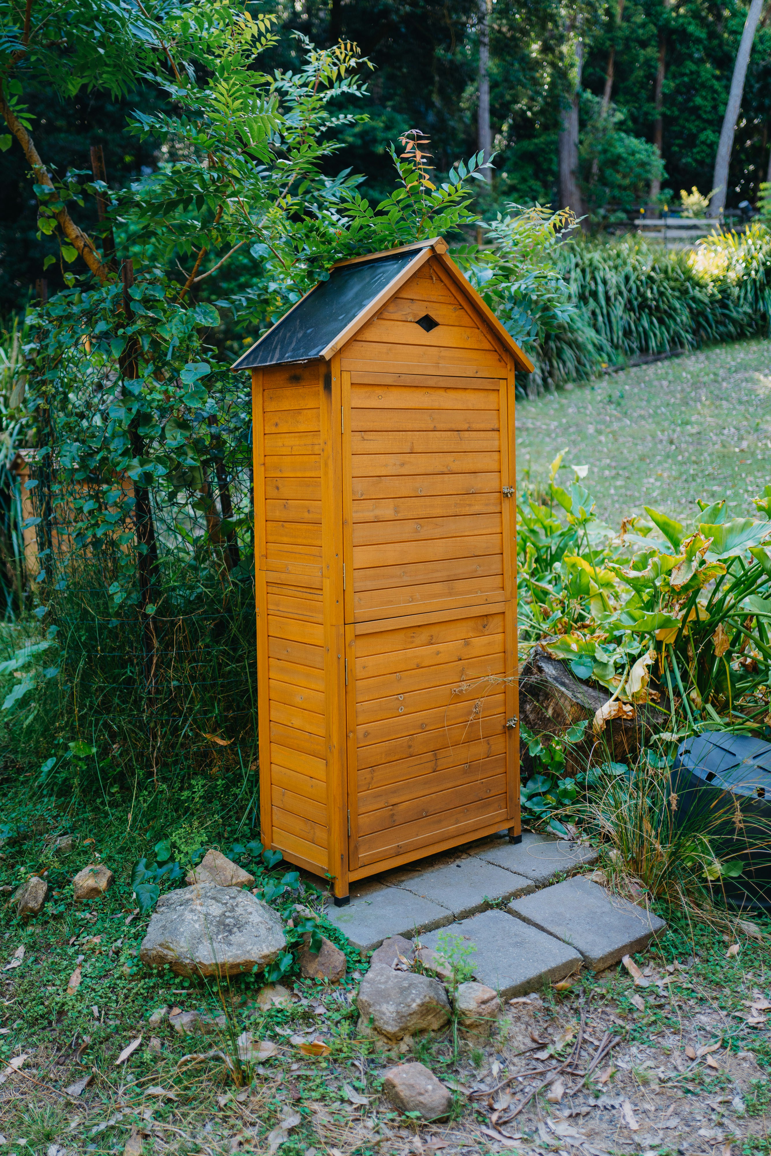 Una pequeña letrina de madera en medio de un jardín foto – Imagen de ...