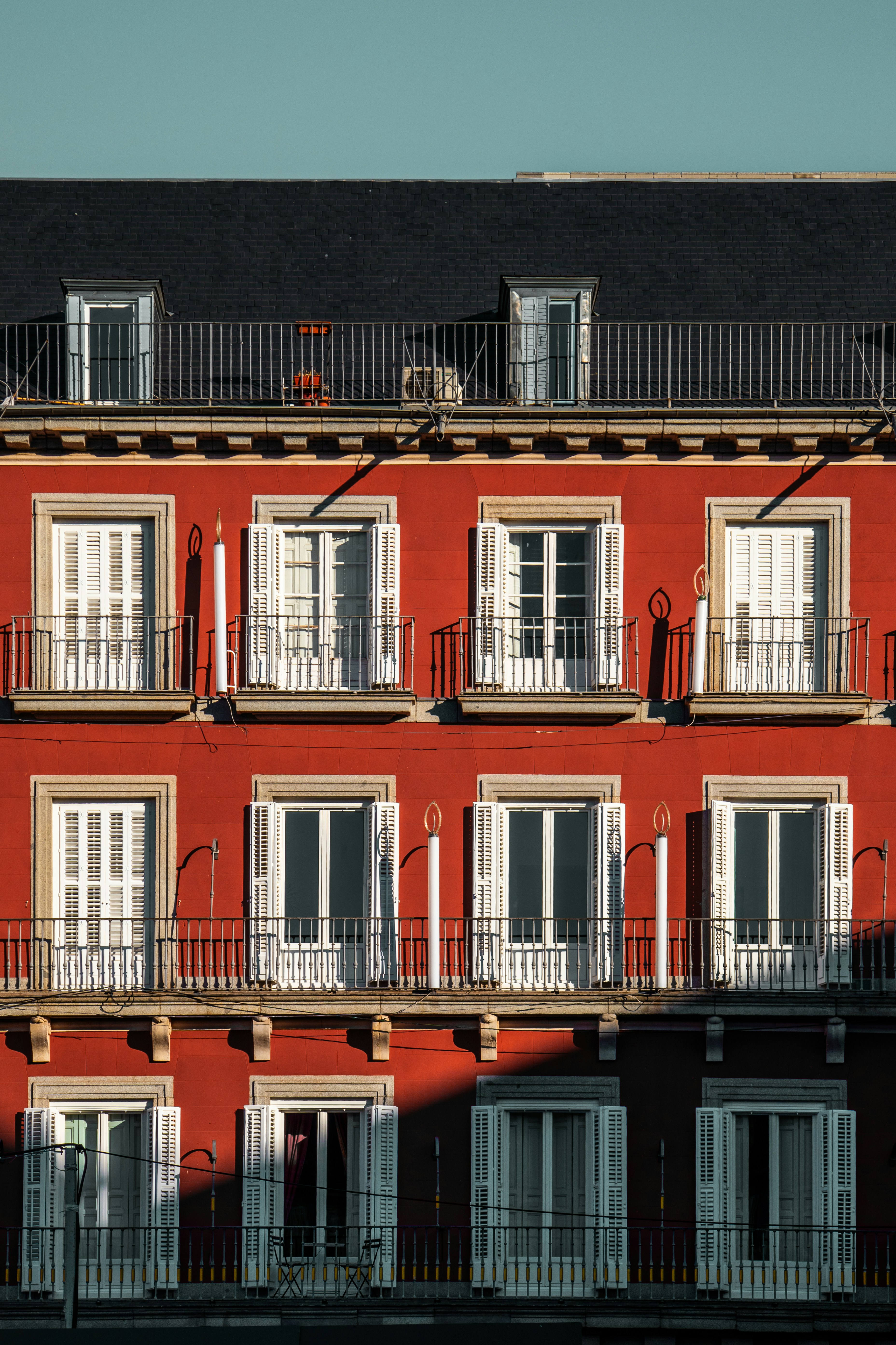 A red building with white windows and balconies photo – Free City Image ...