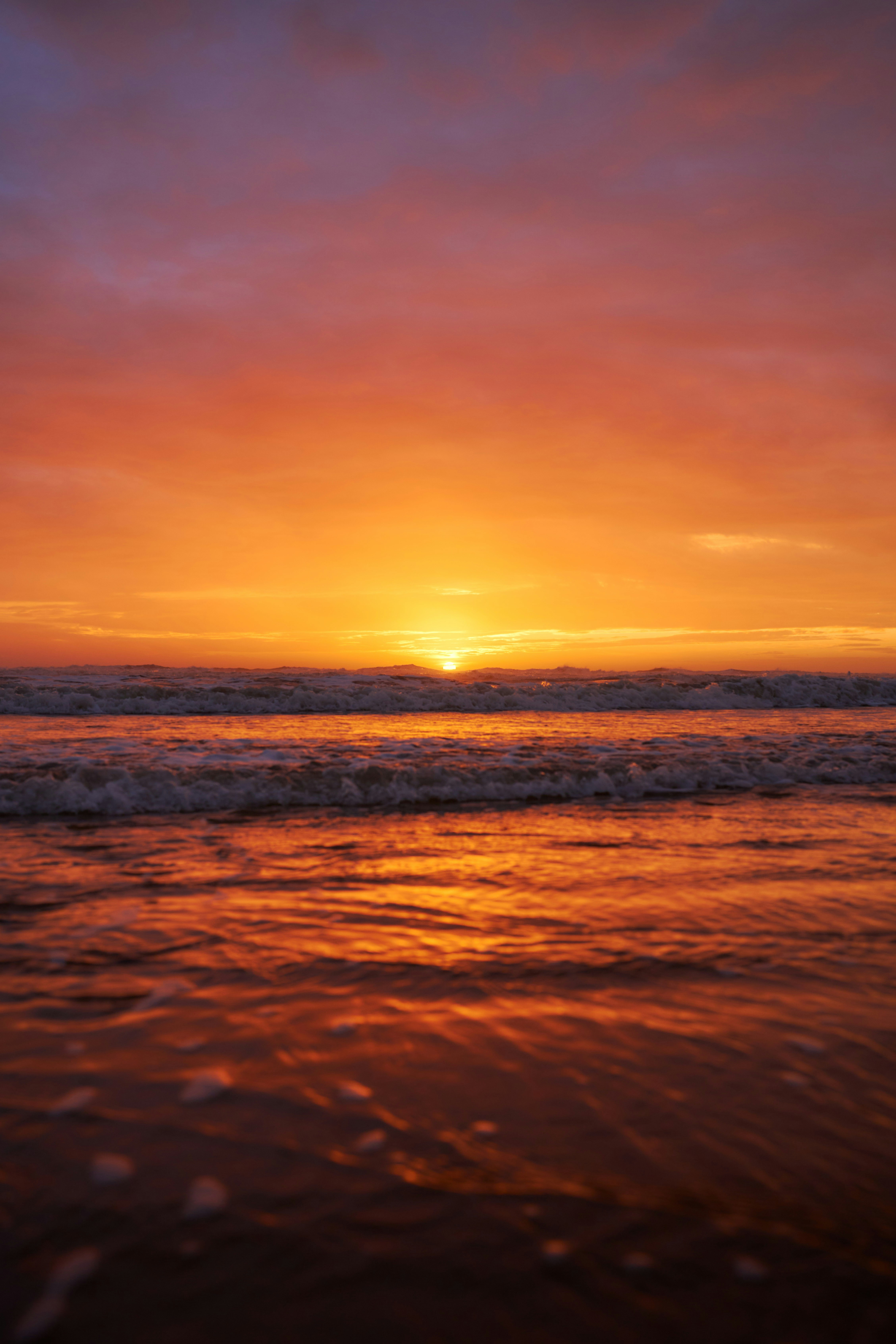 Horizon Ablaze: Sunset Over a Rippling Tide