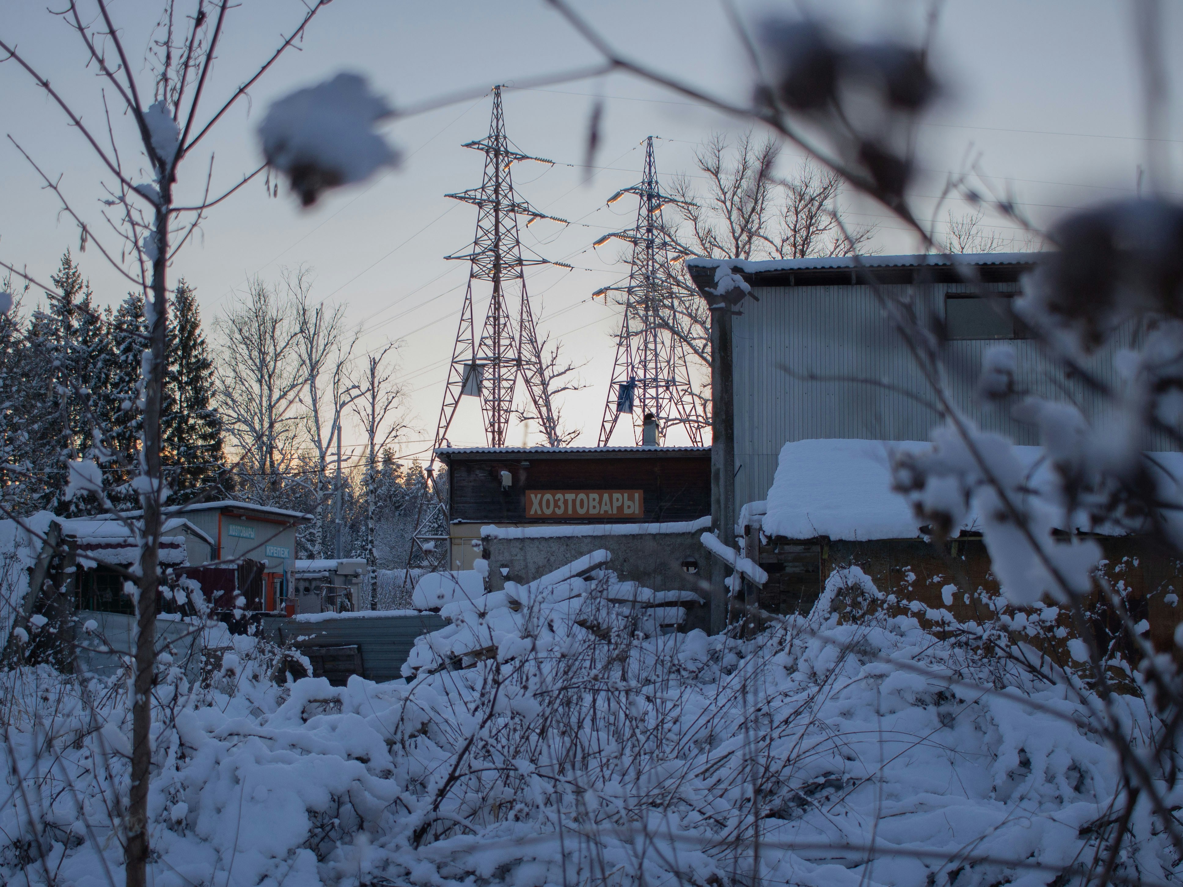 Dusk Over a Snowbound Outpost Behind Transmission Towers