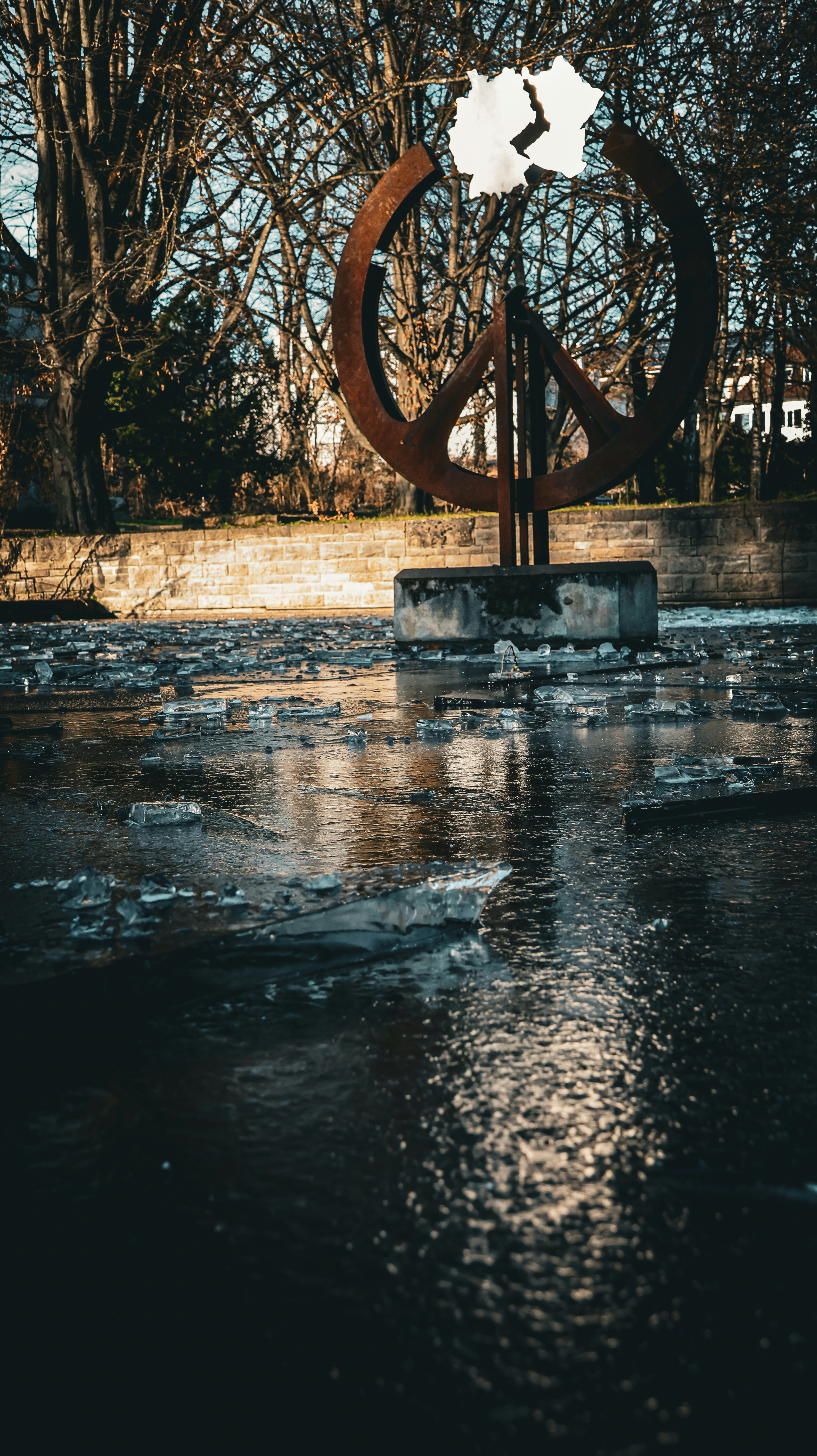 Rust Ring in Frost: A Quiet Park Sculpture Illuminated by Winter Light