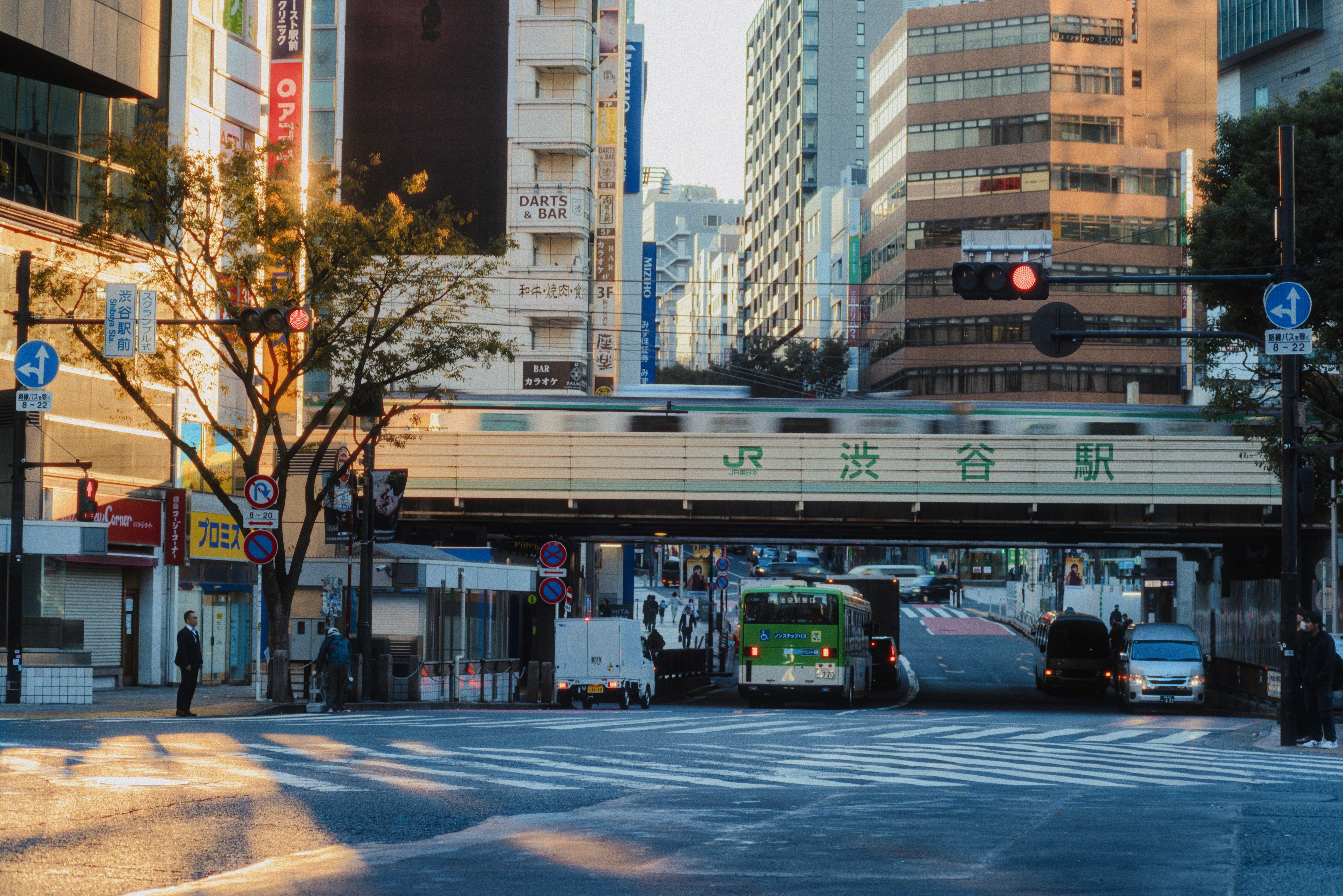 A city street with a train crossing over it photo – Free Street ...