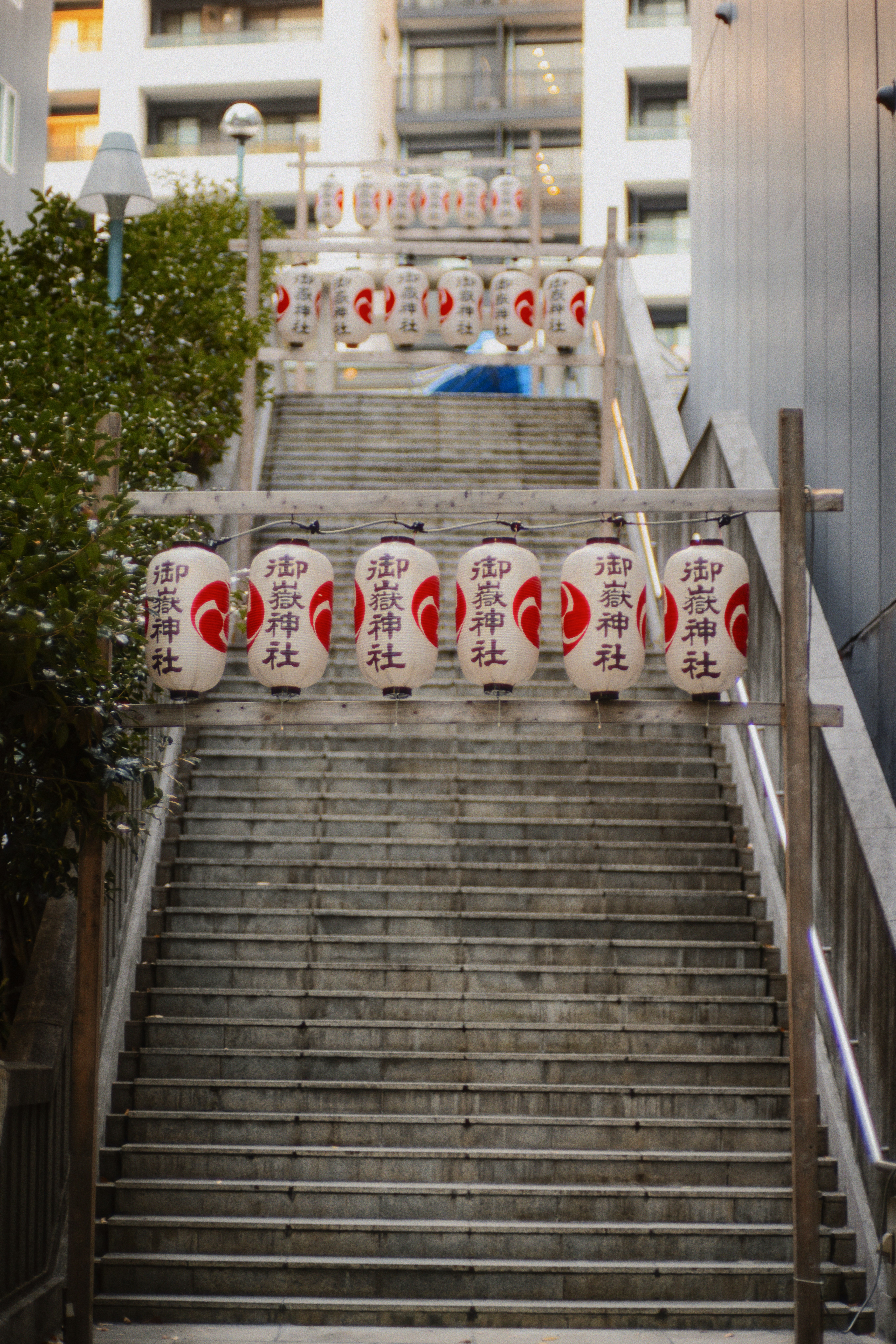 Lanterns Across the Ascent: A Shrine Staircase in Urban Japan