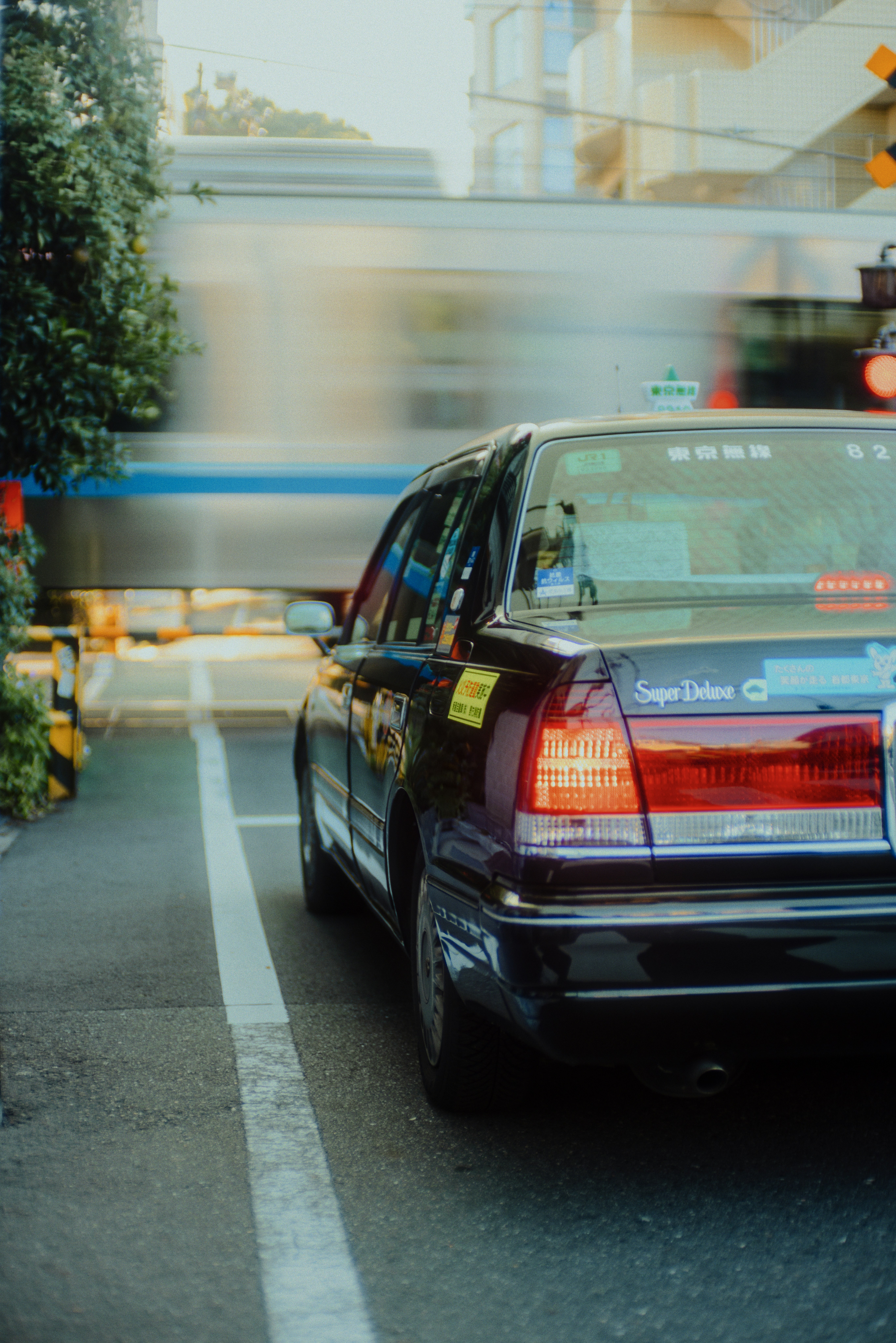 A taxi cab driving down a street next to a train photo – Free Car Image ...