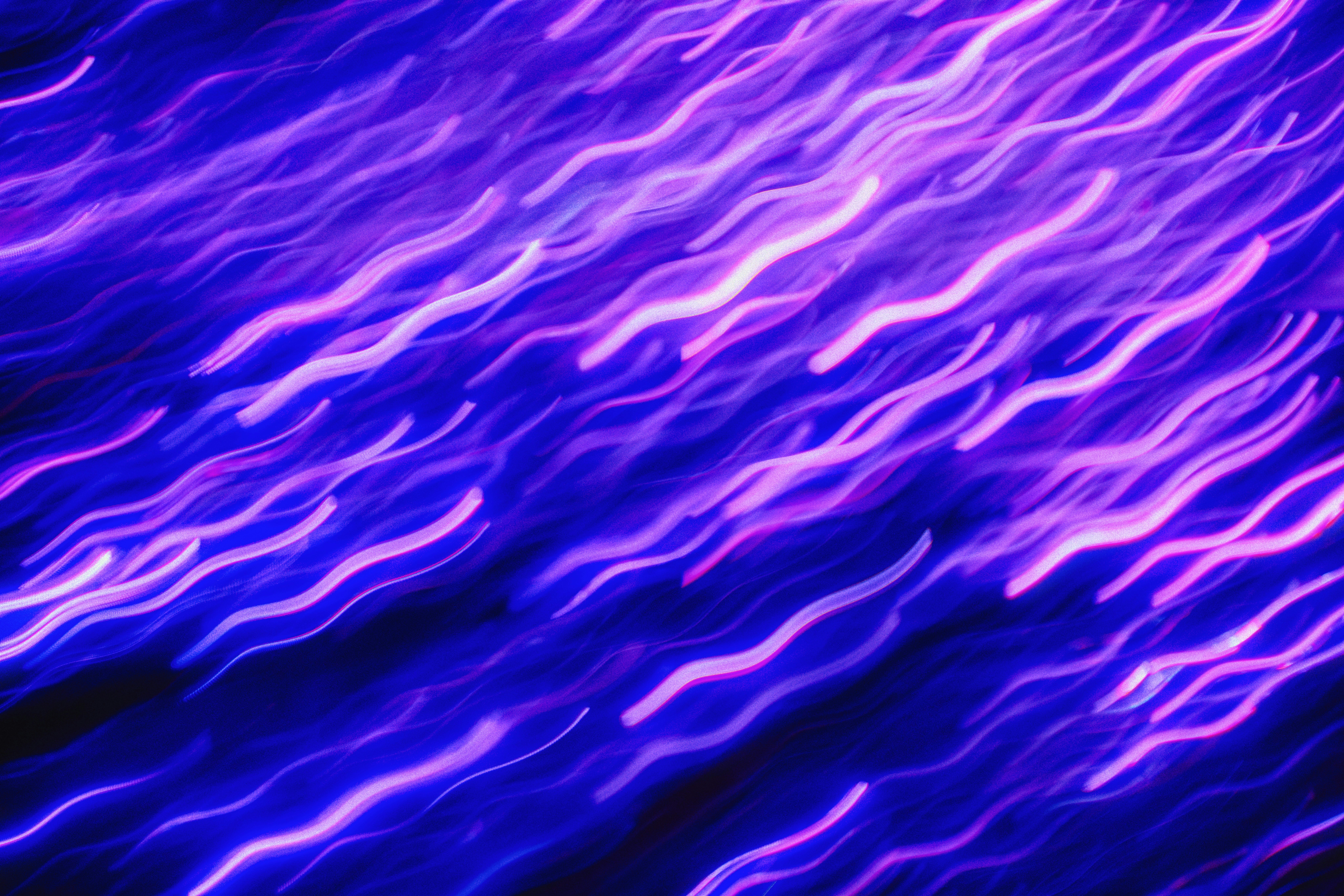 Neon Ribbon Currents: Purple Light Trails in a Dark Motion
