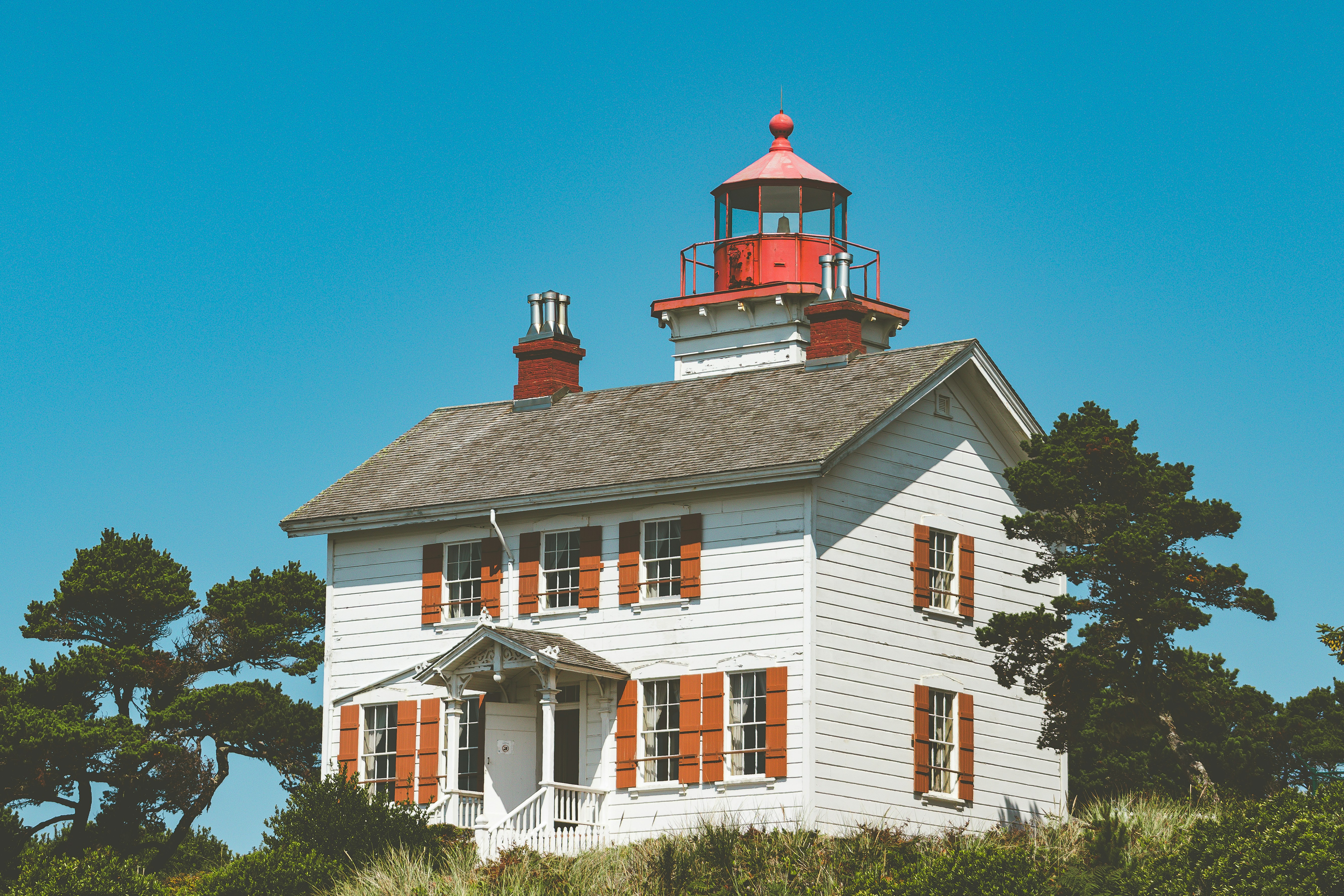 A white house with red shutters and a light tower photo – Free Yaquina ...