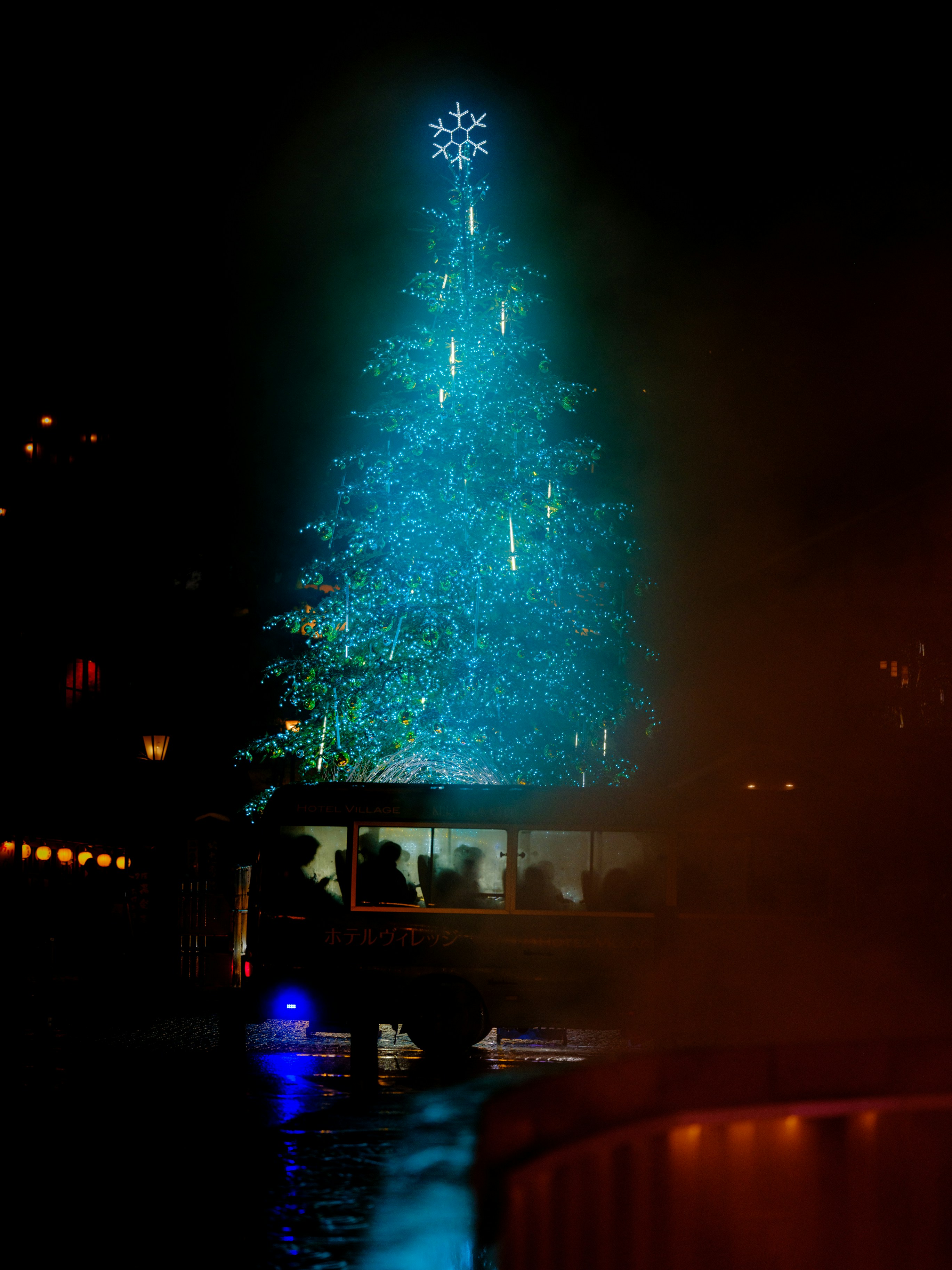 A large christmas tree is lit up in the dark