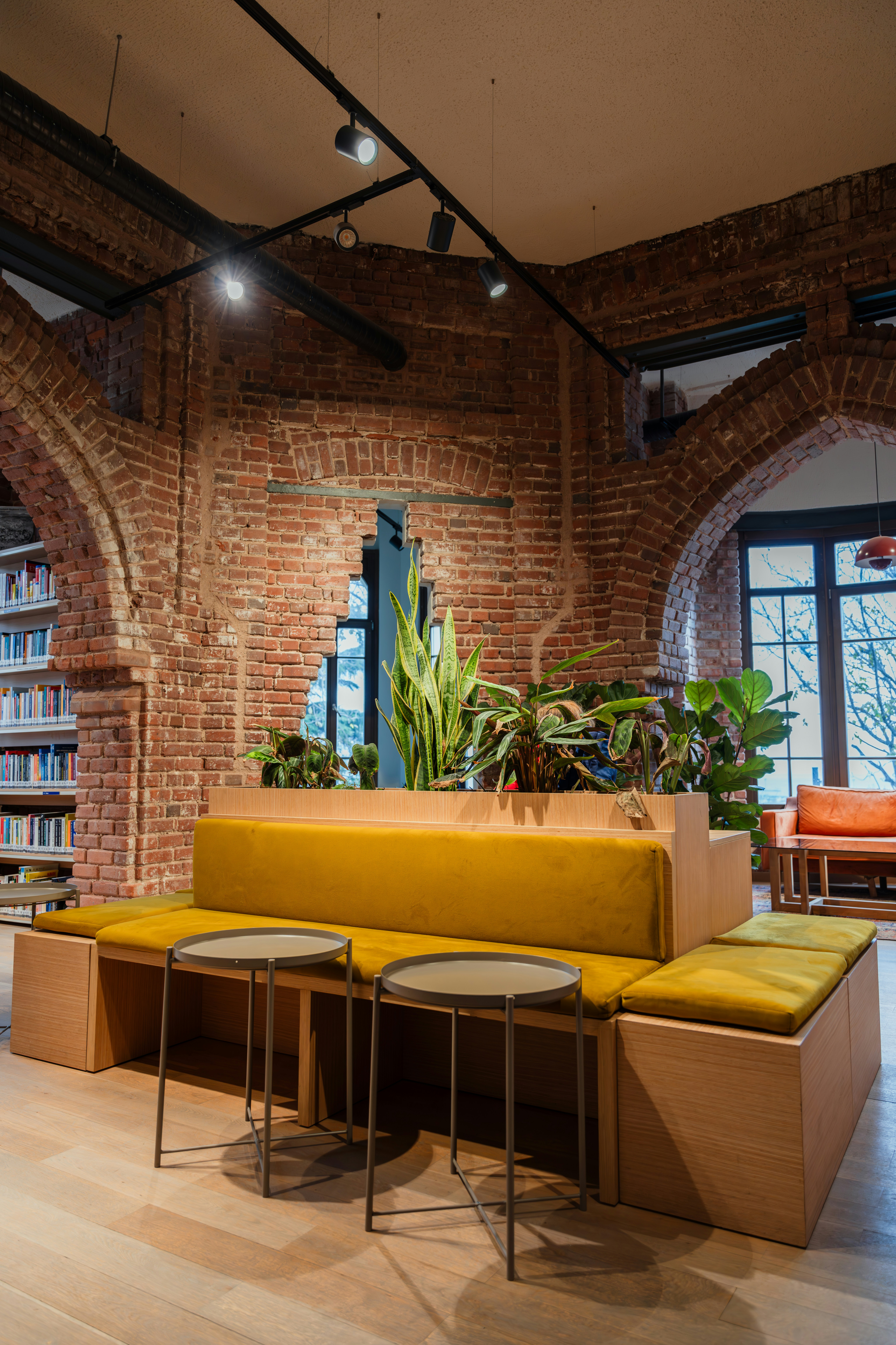 A room with a couch, tables, and a book shelf photo – Free Interior ...