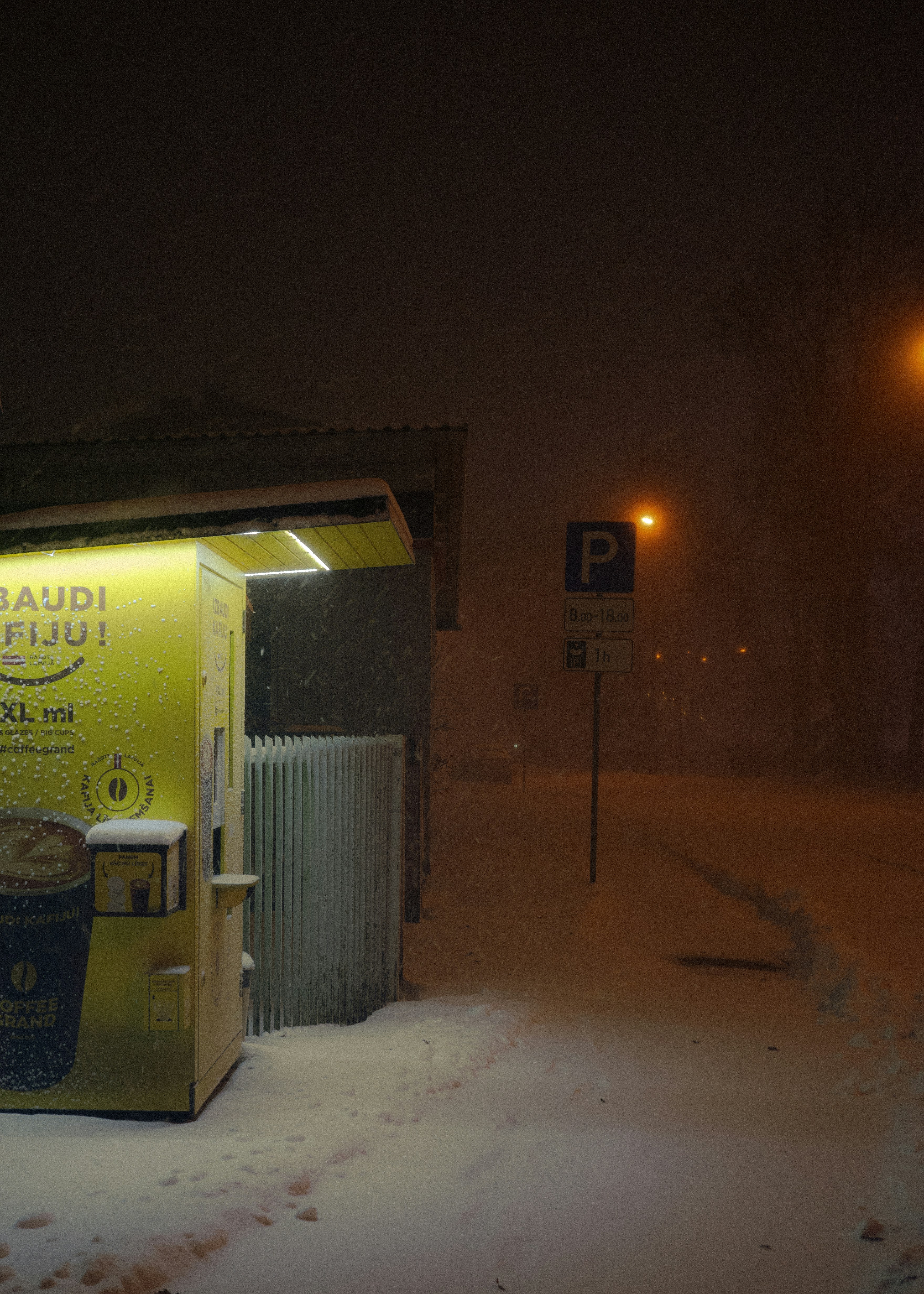 Snowbound Night: The Yellow Vending Machine Standing Watch on a Quiet Street