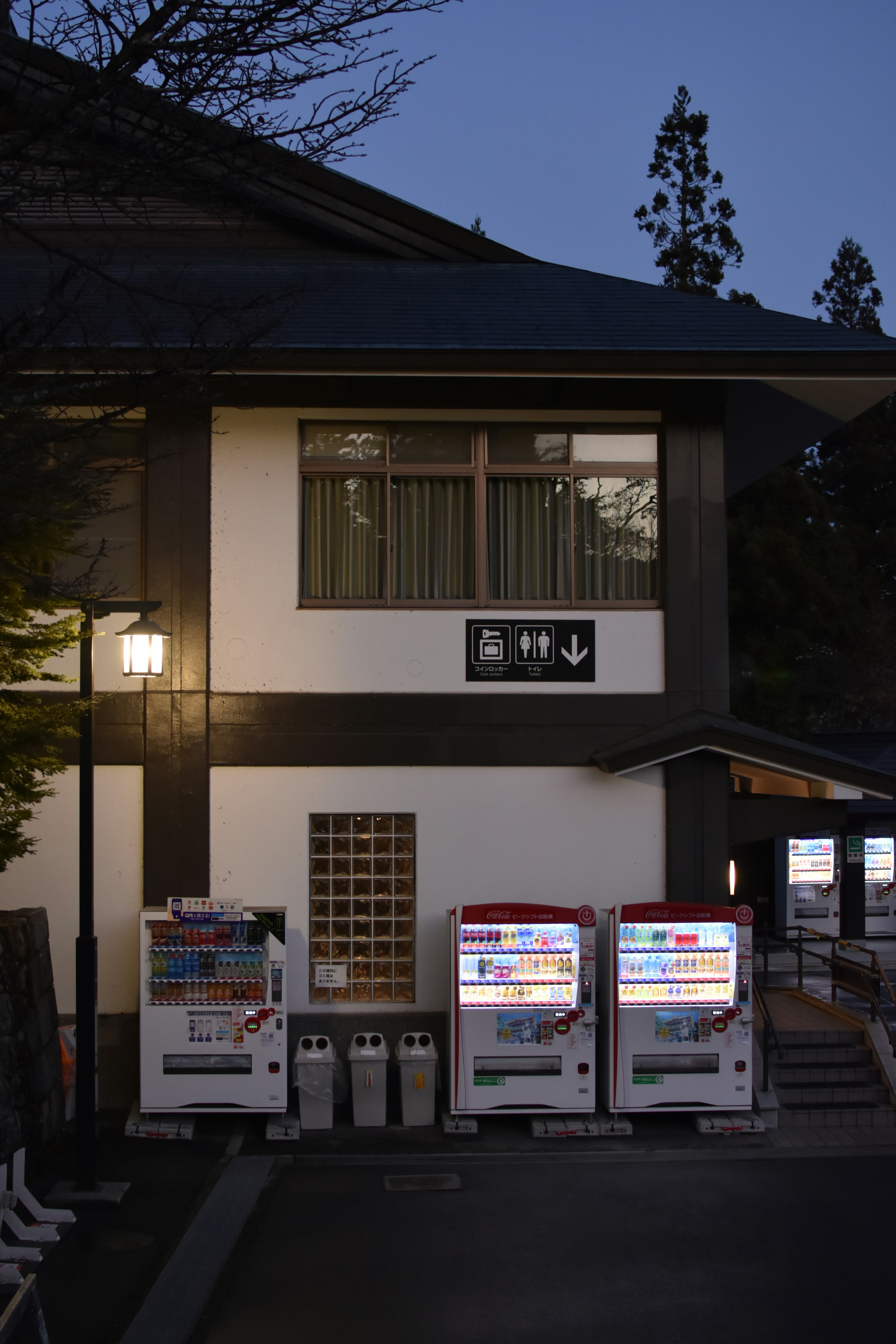 Dusk at the Lodge: Vending Machines Quietly Stand Along a Tranquil Facade
