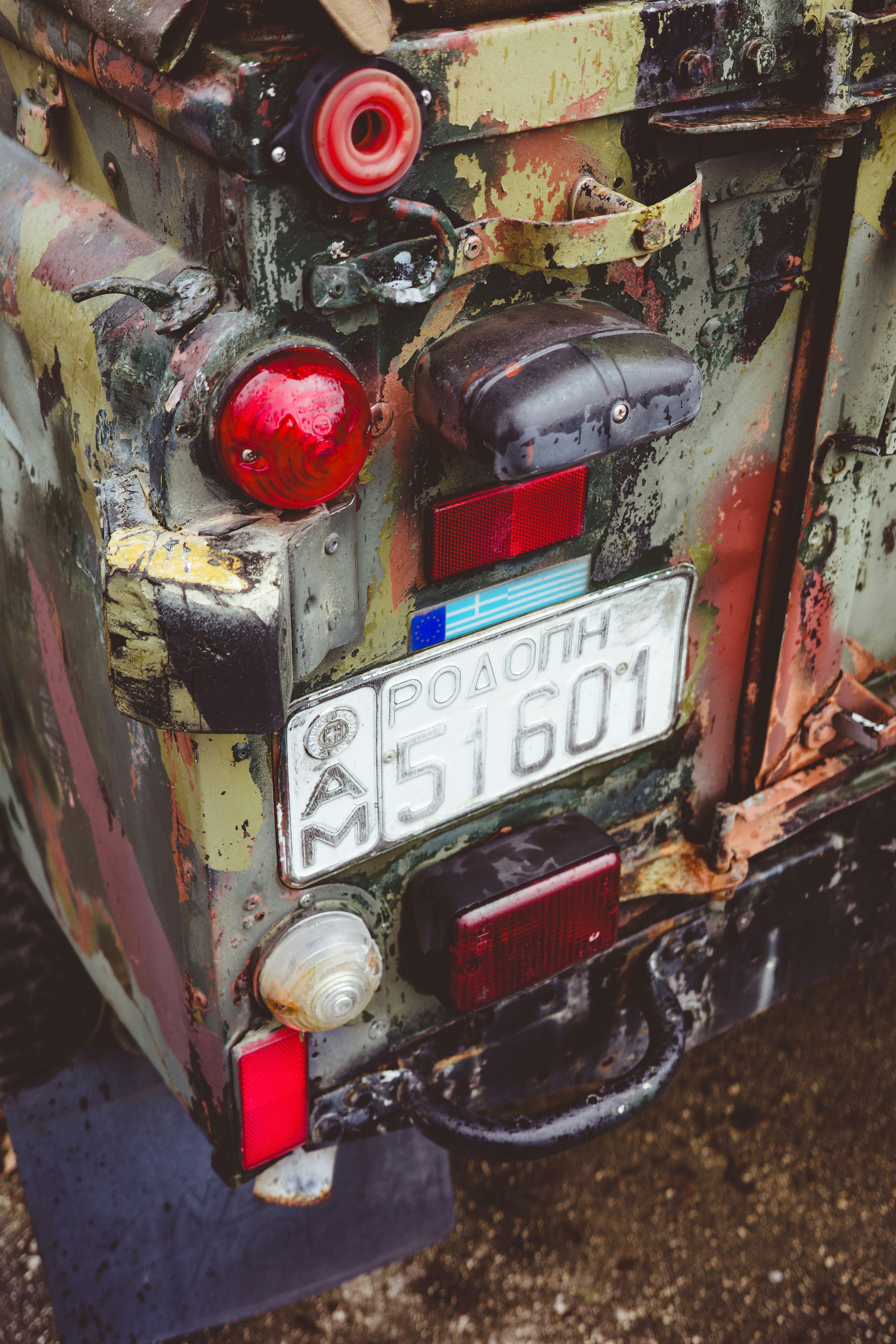 Patina Portrait: Close-Up of a Rusted Tail End with Cracked Paint and License Plate