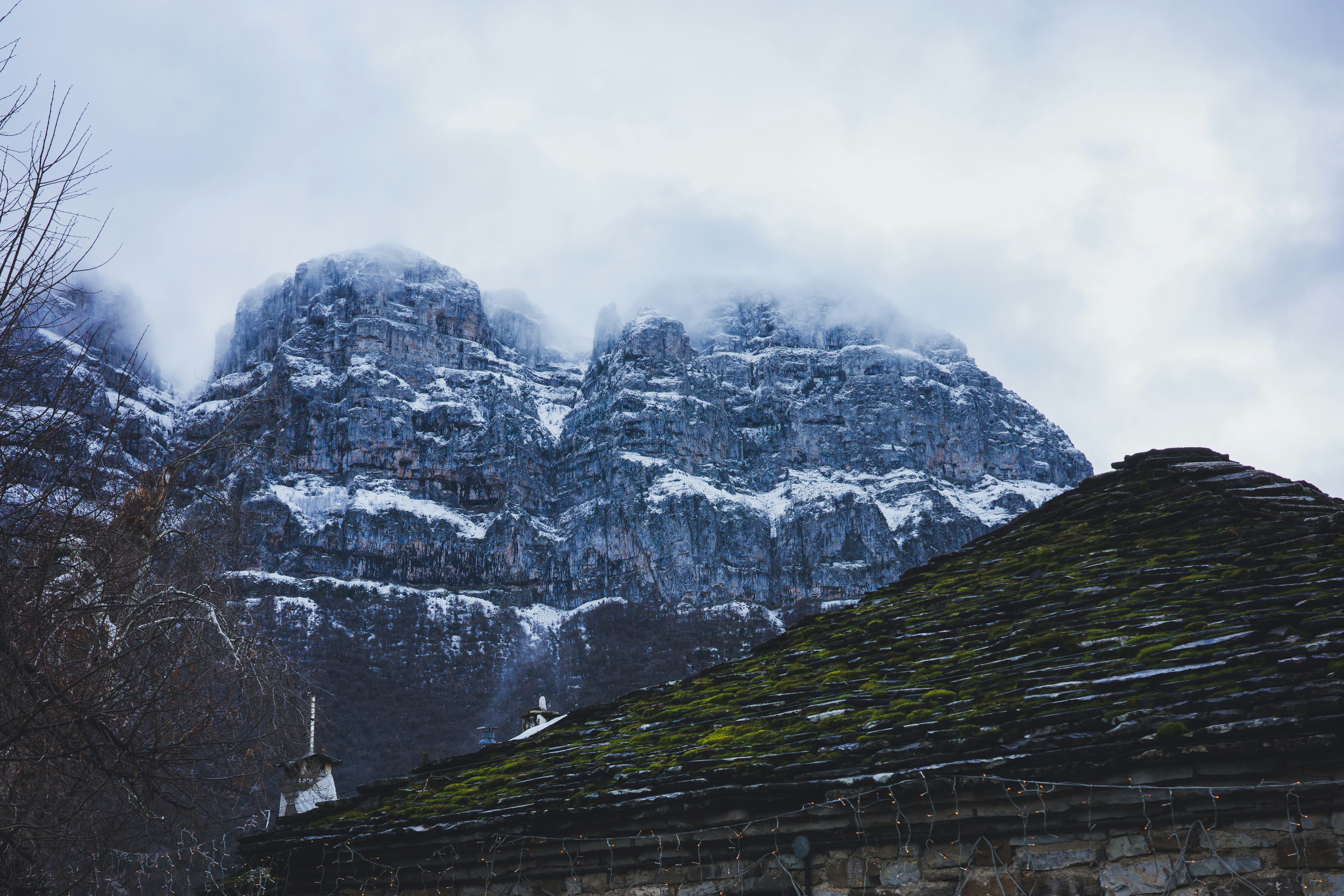 A stone building with a mountain in the background photo – Free Papigo ...