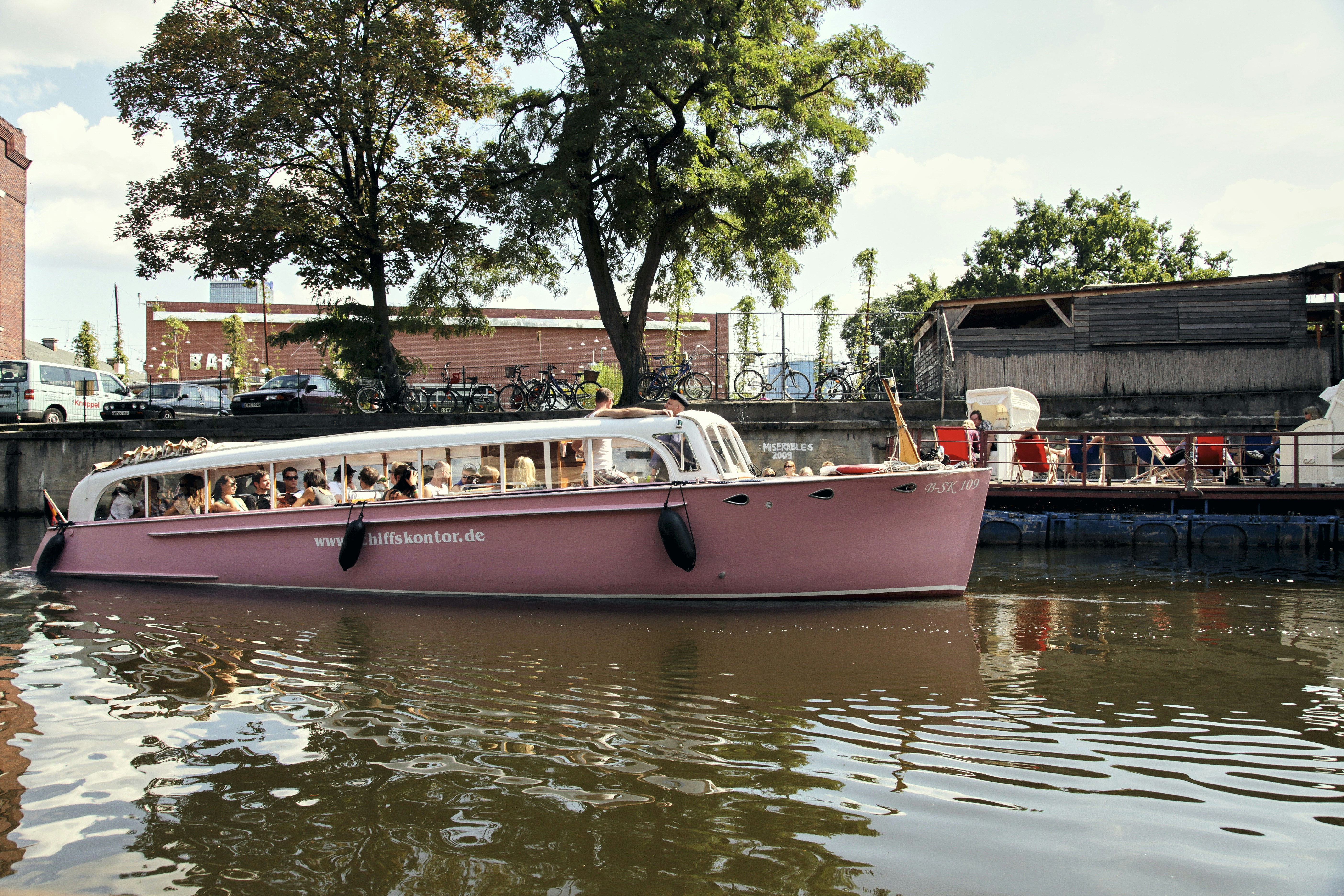 Pastel Pink Riverboat: Quiet Glide Along an Urban Canal
