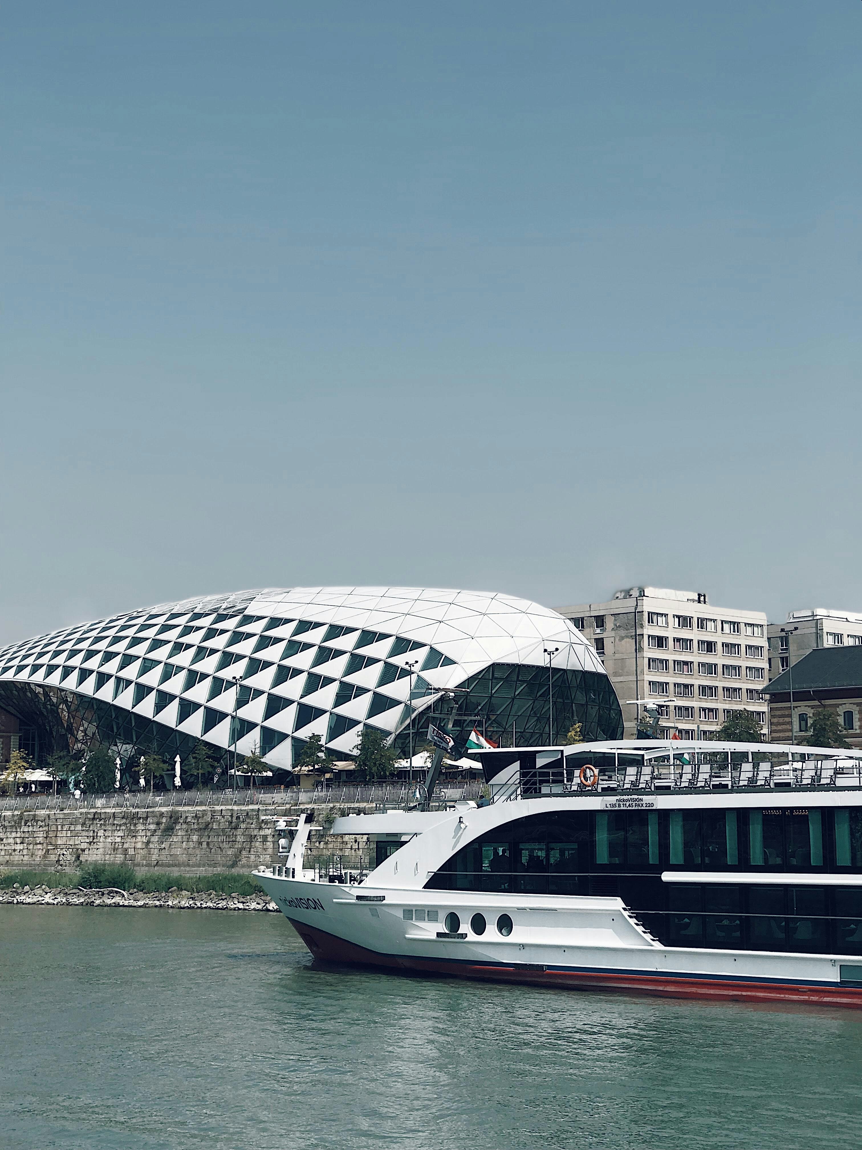 Harbor Vessel Rounding the Modern Dome: A Cityscape by the River