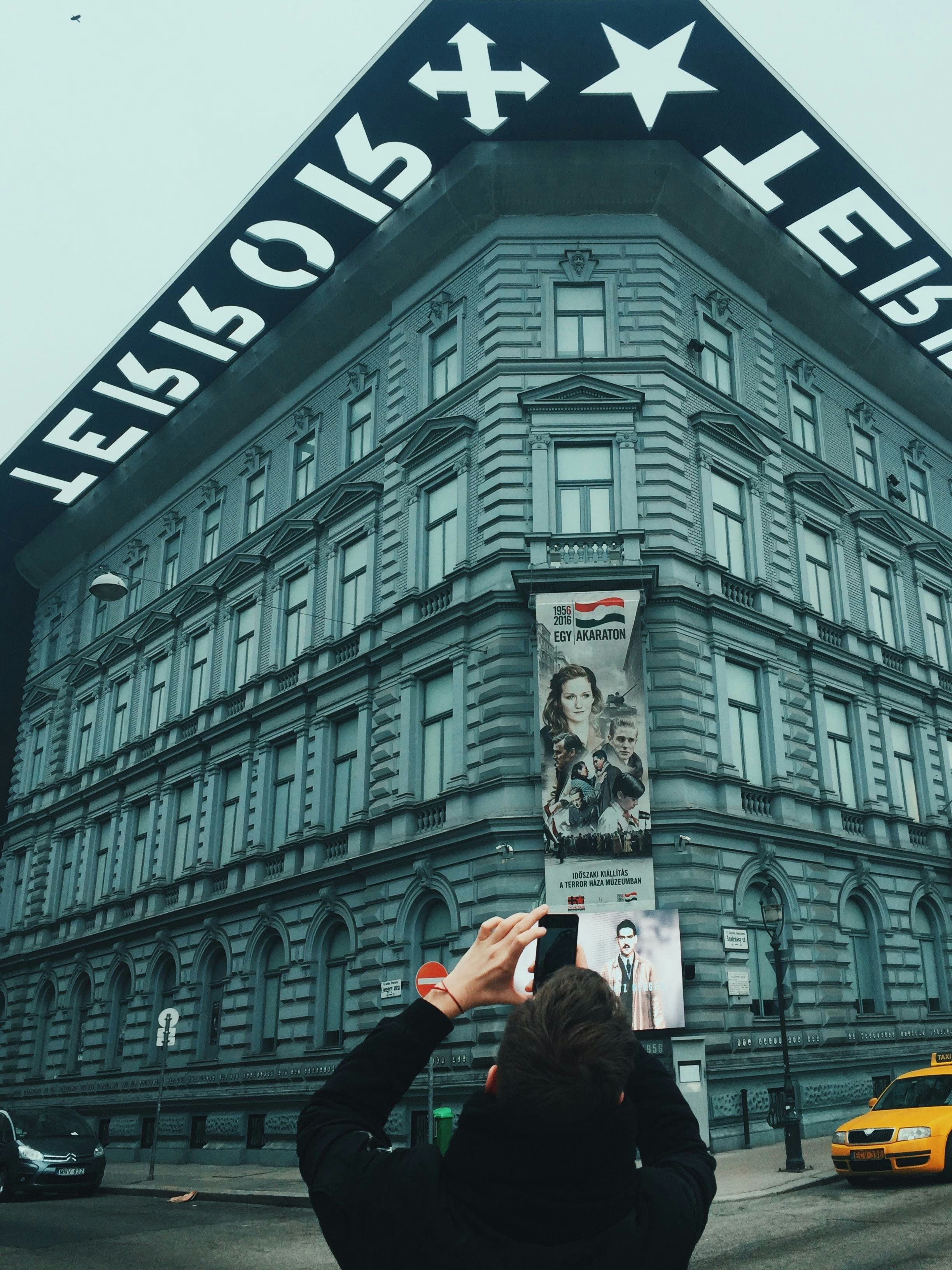 Bottom-Up Frame: A Photographer Captures the Grand Facade Beneath a Bold Diagonal Sign