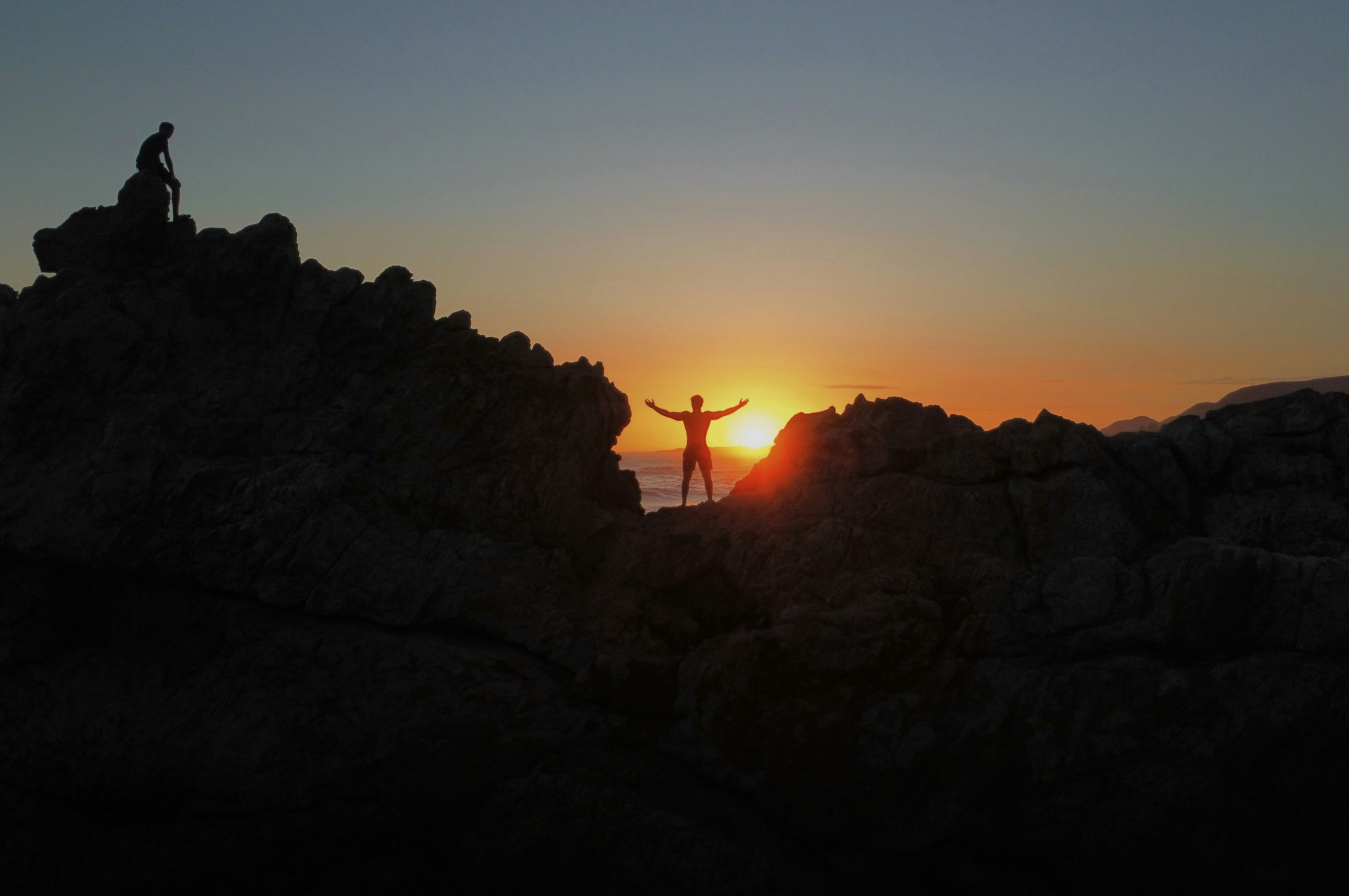 A person standing on top of a mountain at sunset photo – Free Hermanus ...