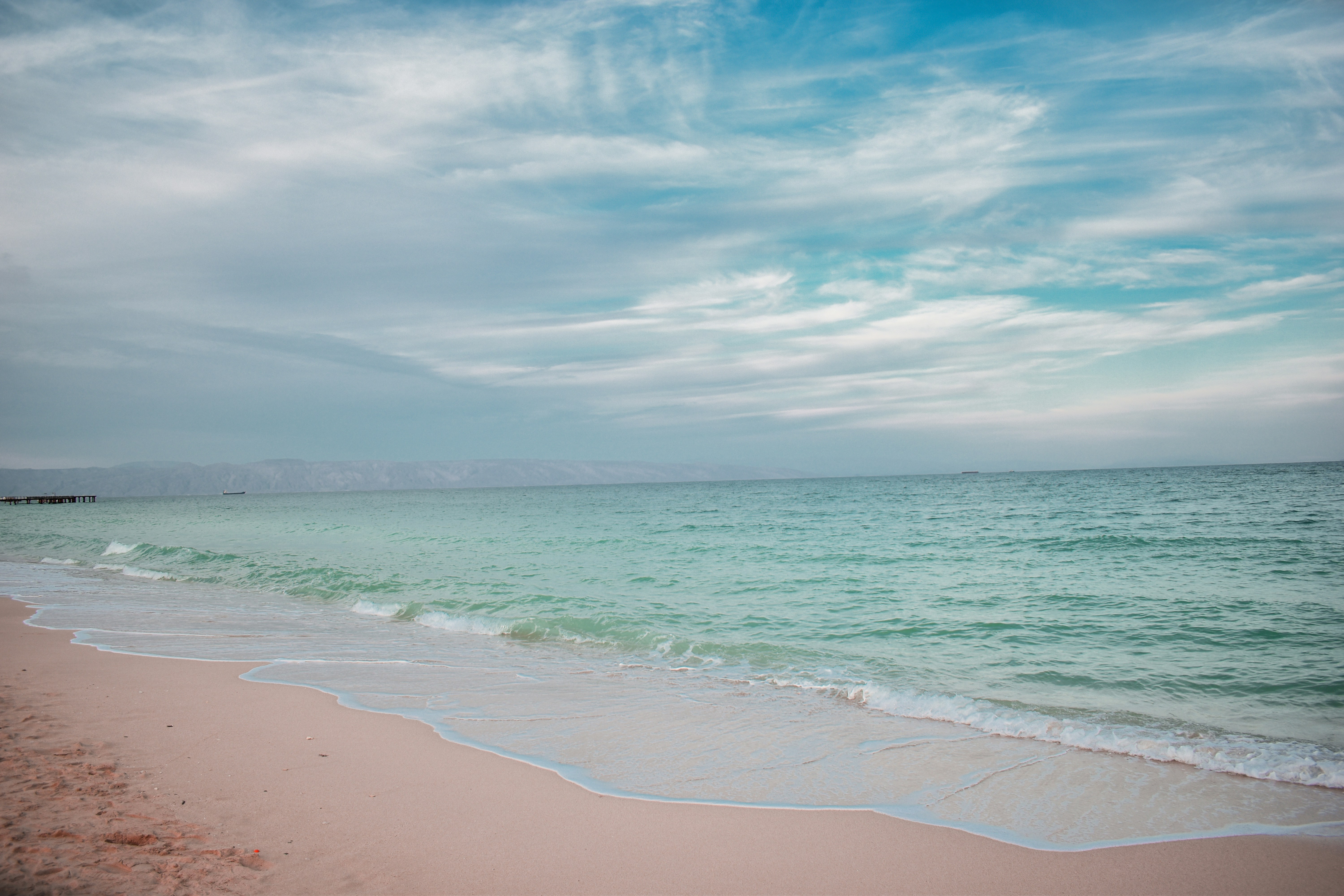 A sandy beach with waves coming in to shore photo – Free Kish island ...