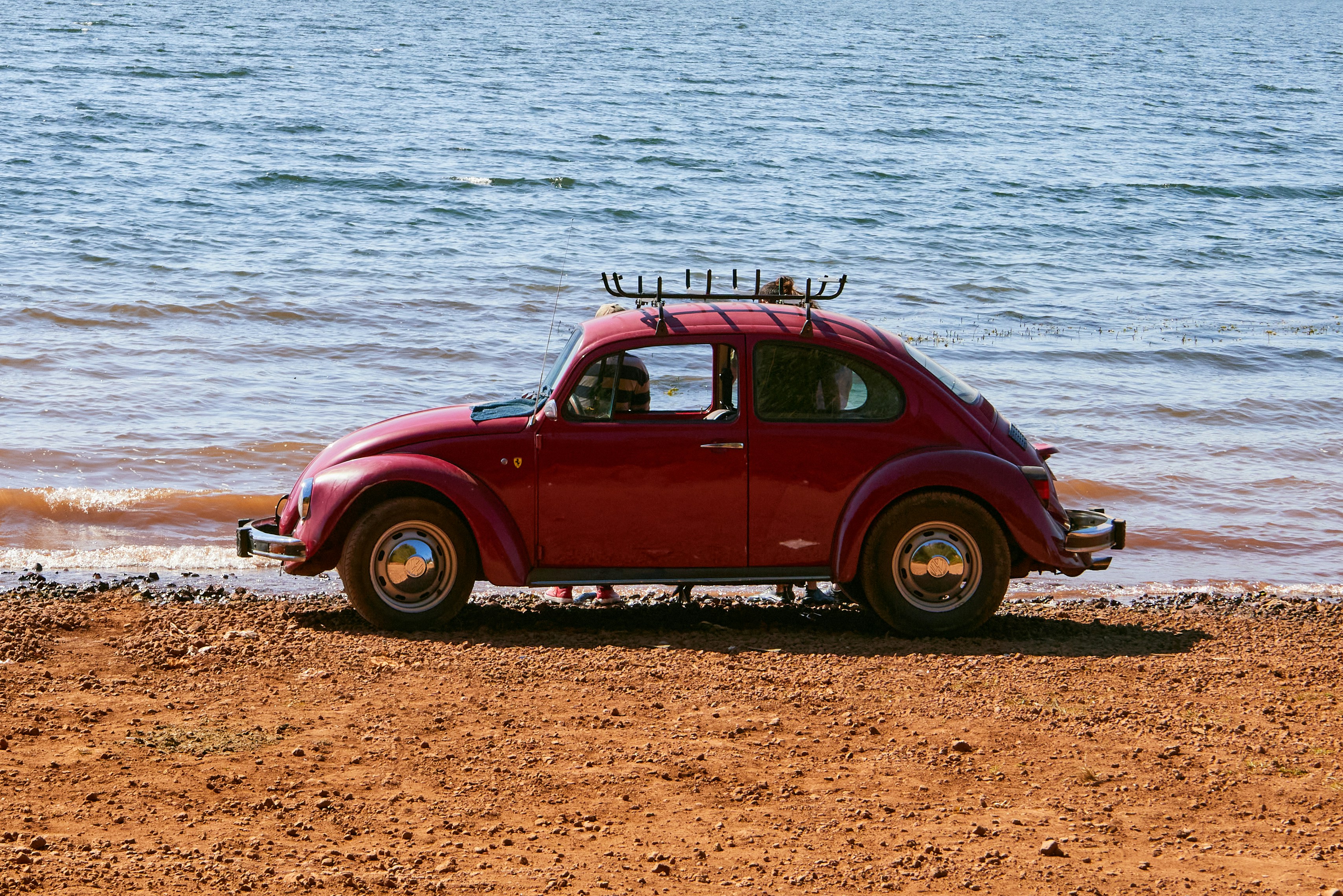 A red car parked on the beach near the water photo – Free Roadtrip ...