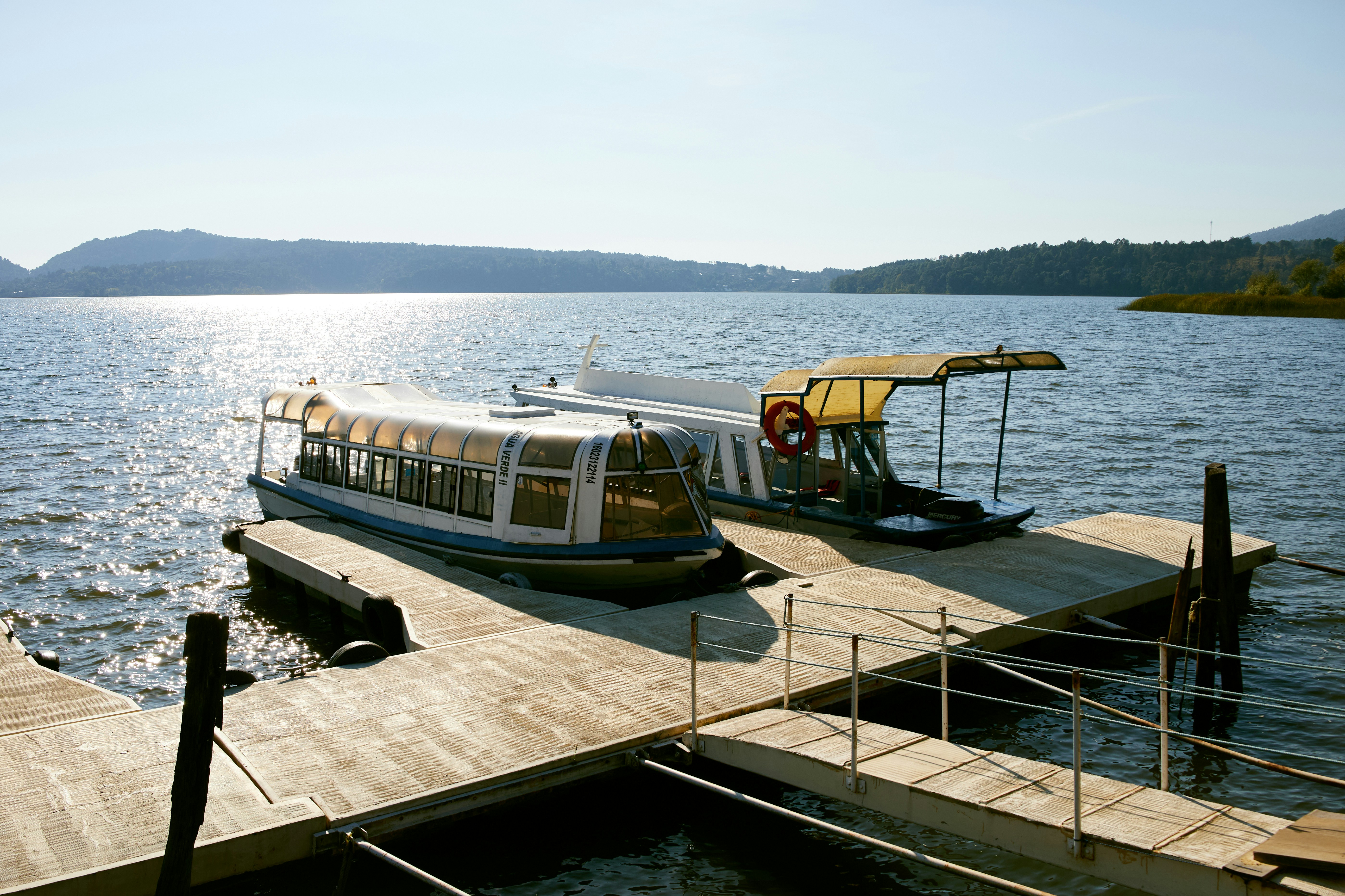 Noon Light on a Quiet Lake: A Glass-Top Tour Boat at the Wooden Dock
