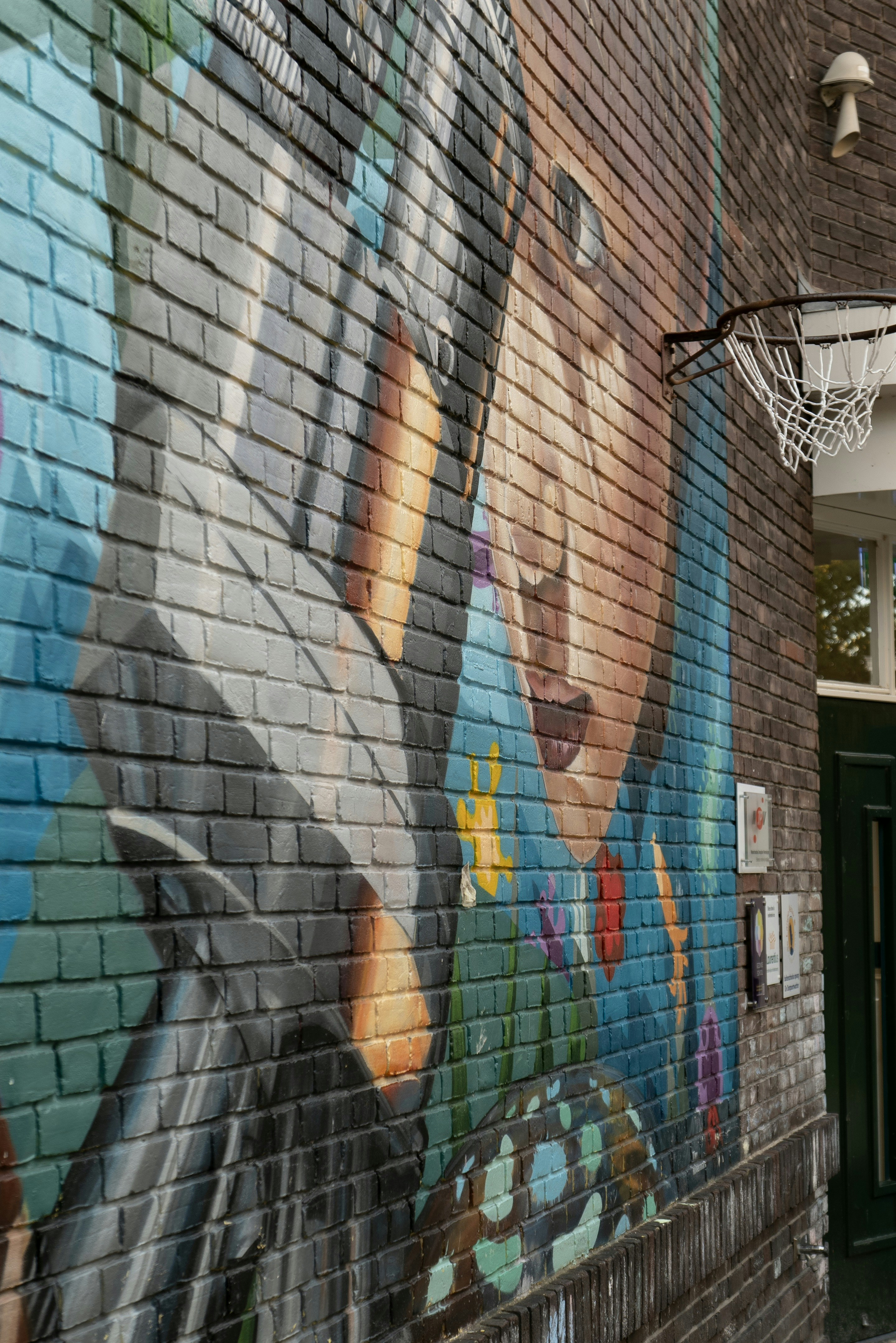 A brick building with a basketball hoop hanging from it's side photo ...