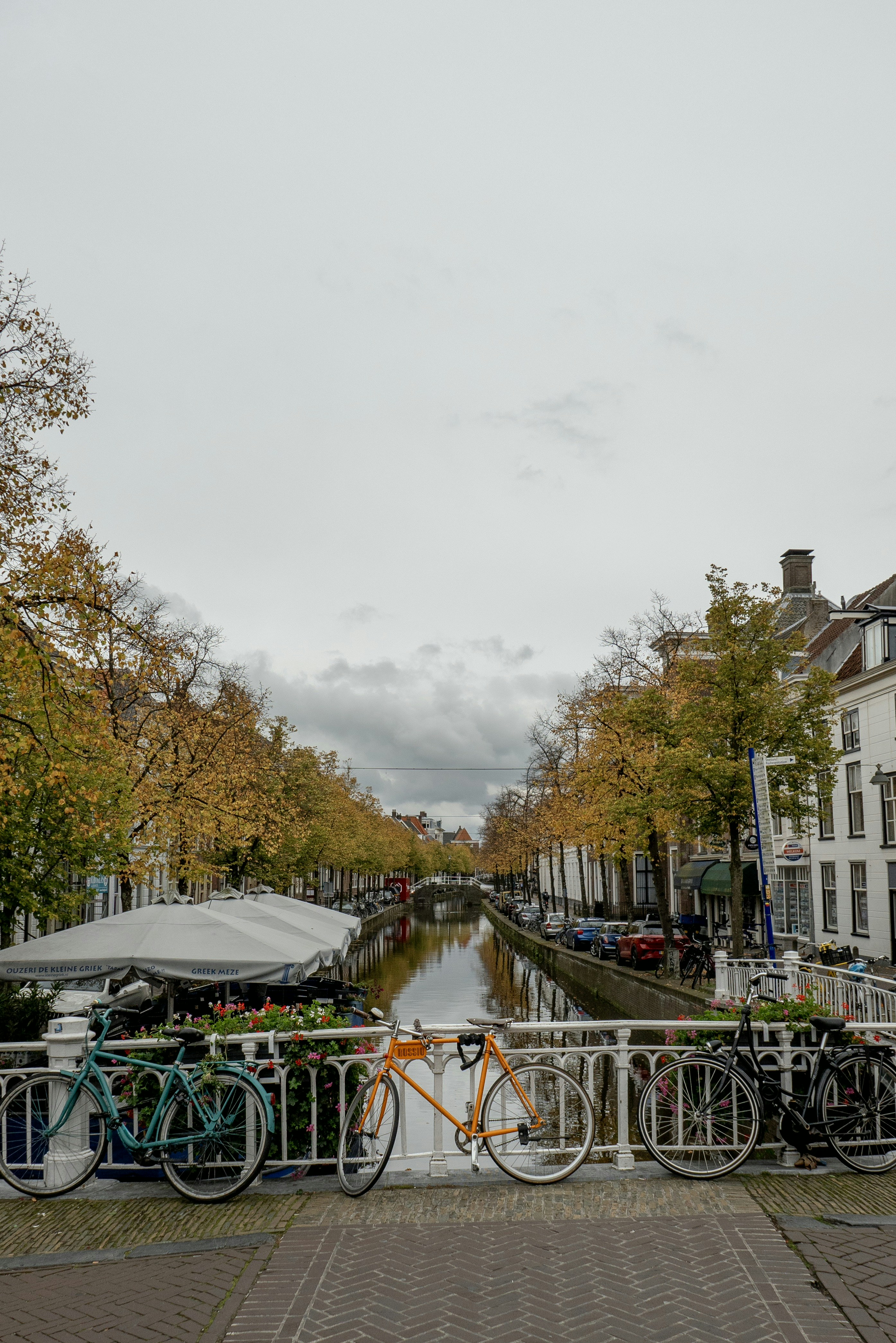Orange Frame on a Canal Bridge: Autumn Bikes Guard the Quiet Waterway