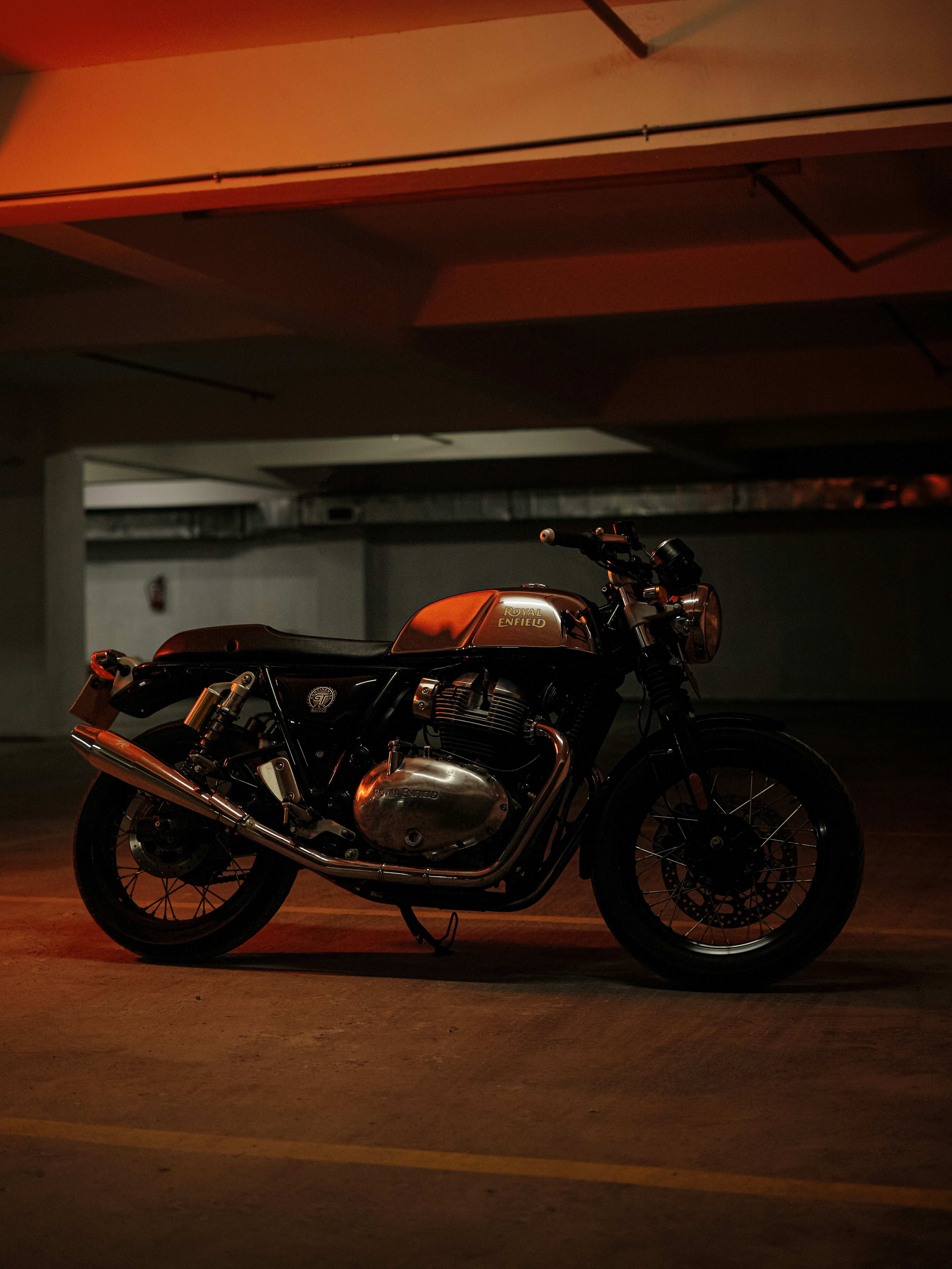 Embers and Chrome: Royal Enfield Under Orange Glow in a Quiet Parking Garage