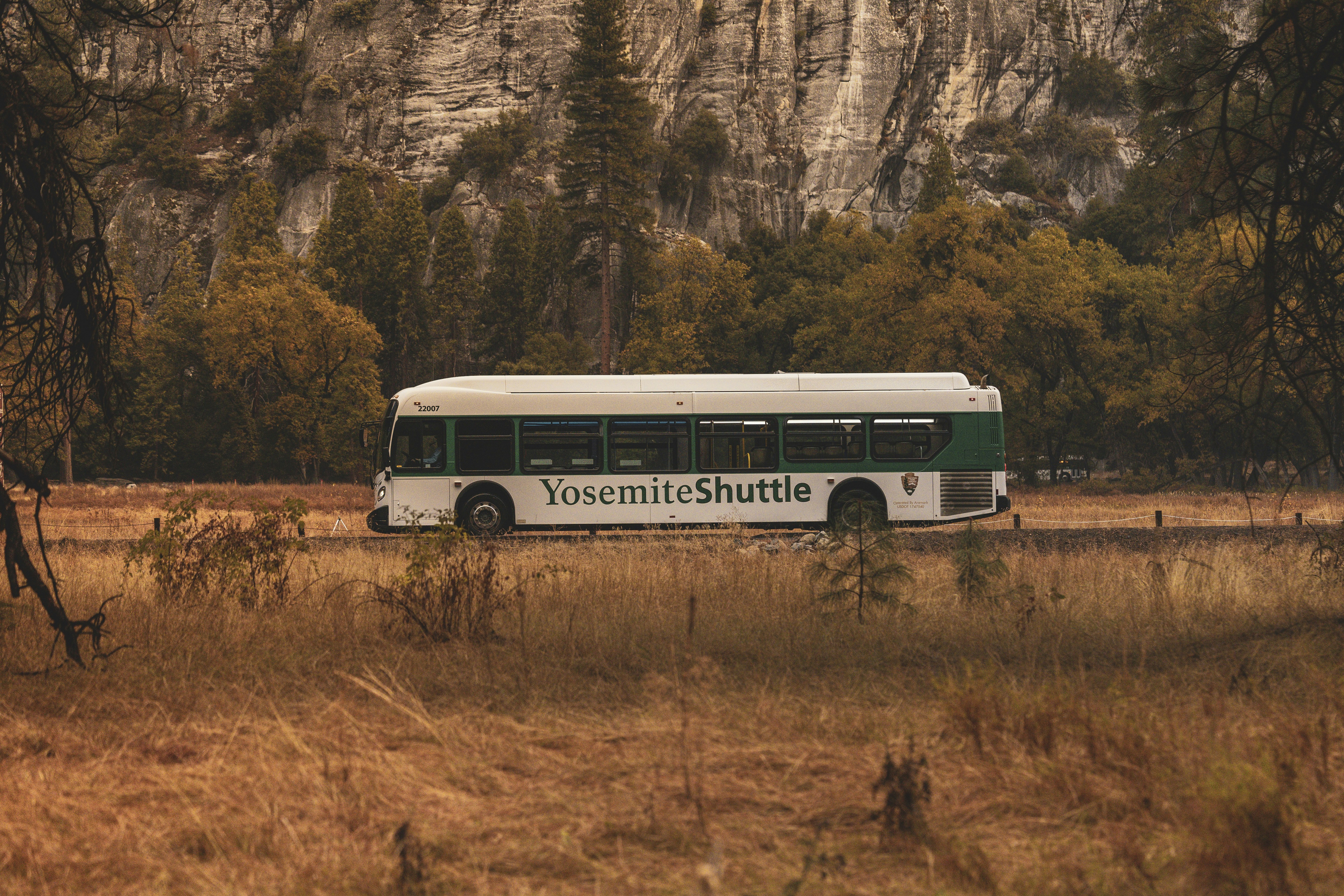 Un bus est garé dans un champ avec une montagne en arrière-plan photo ...