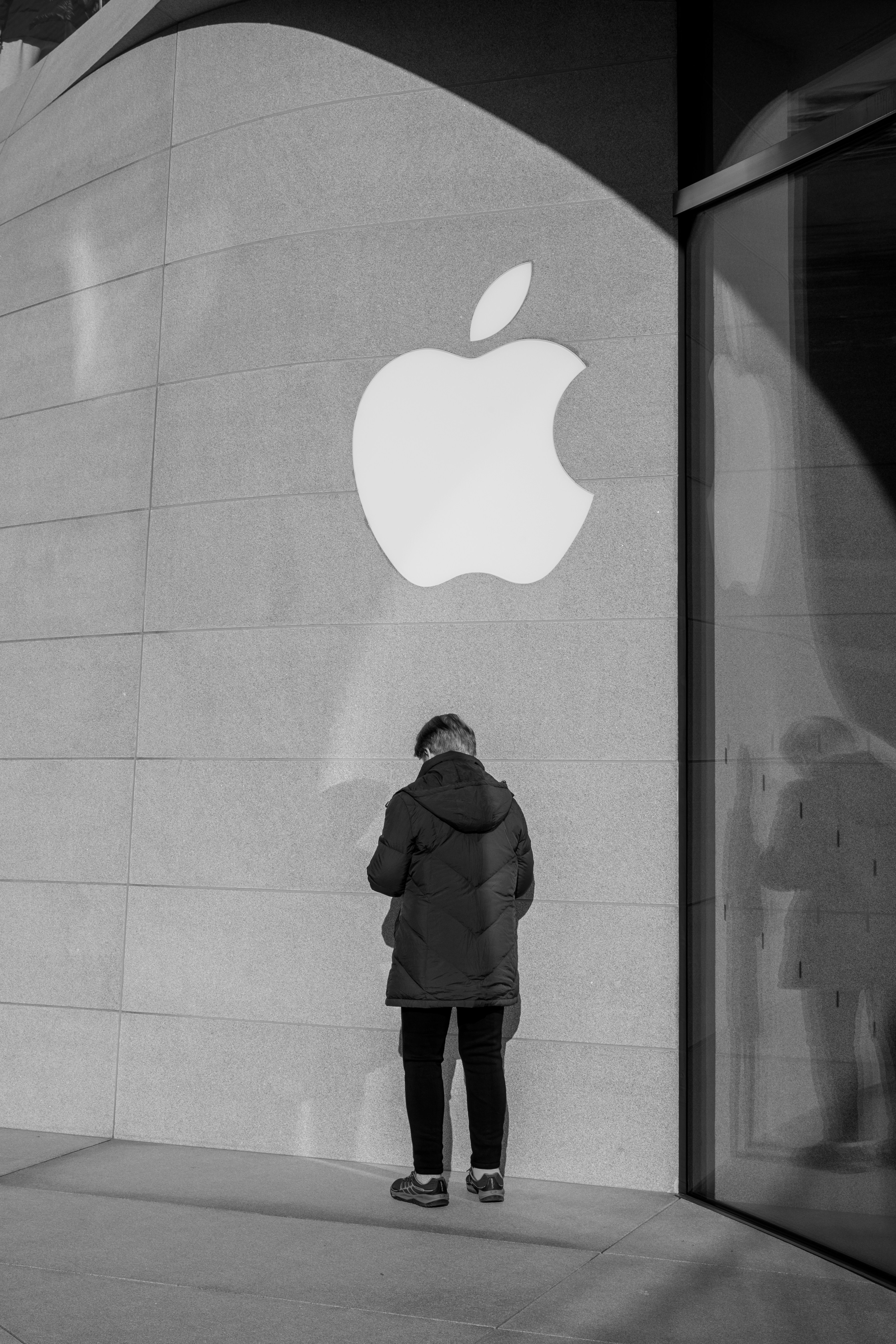 Under the Giant Apple: A Quiet Portrait by a Curved Facade