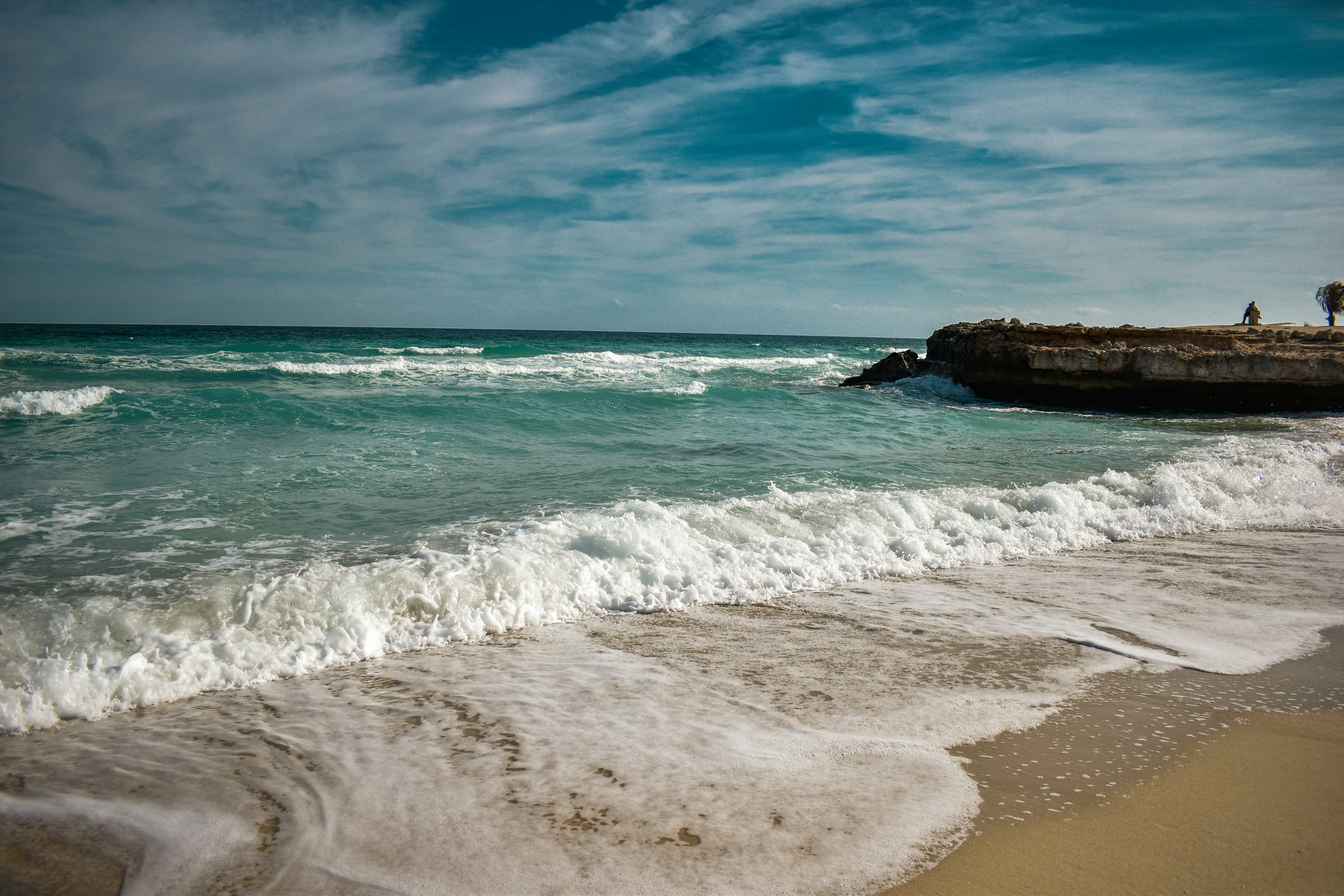 A sandy beach with waves coming in to shore photo – Free Kish island ...