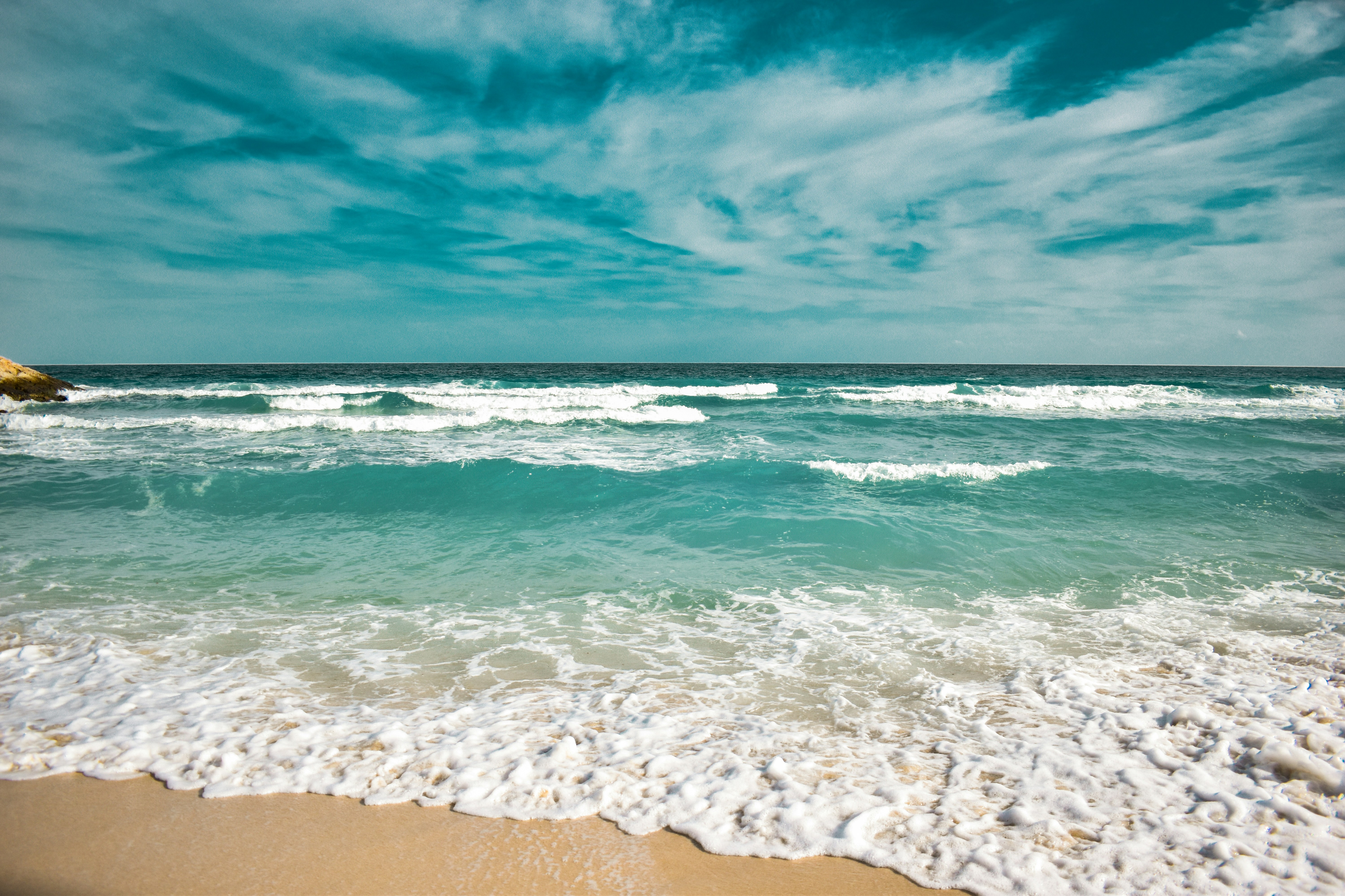 A sandy beach with waves coming in to shore photo – Free Kish island ...