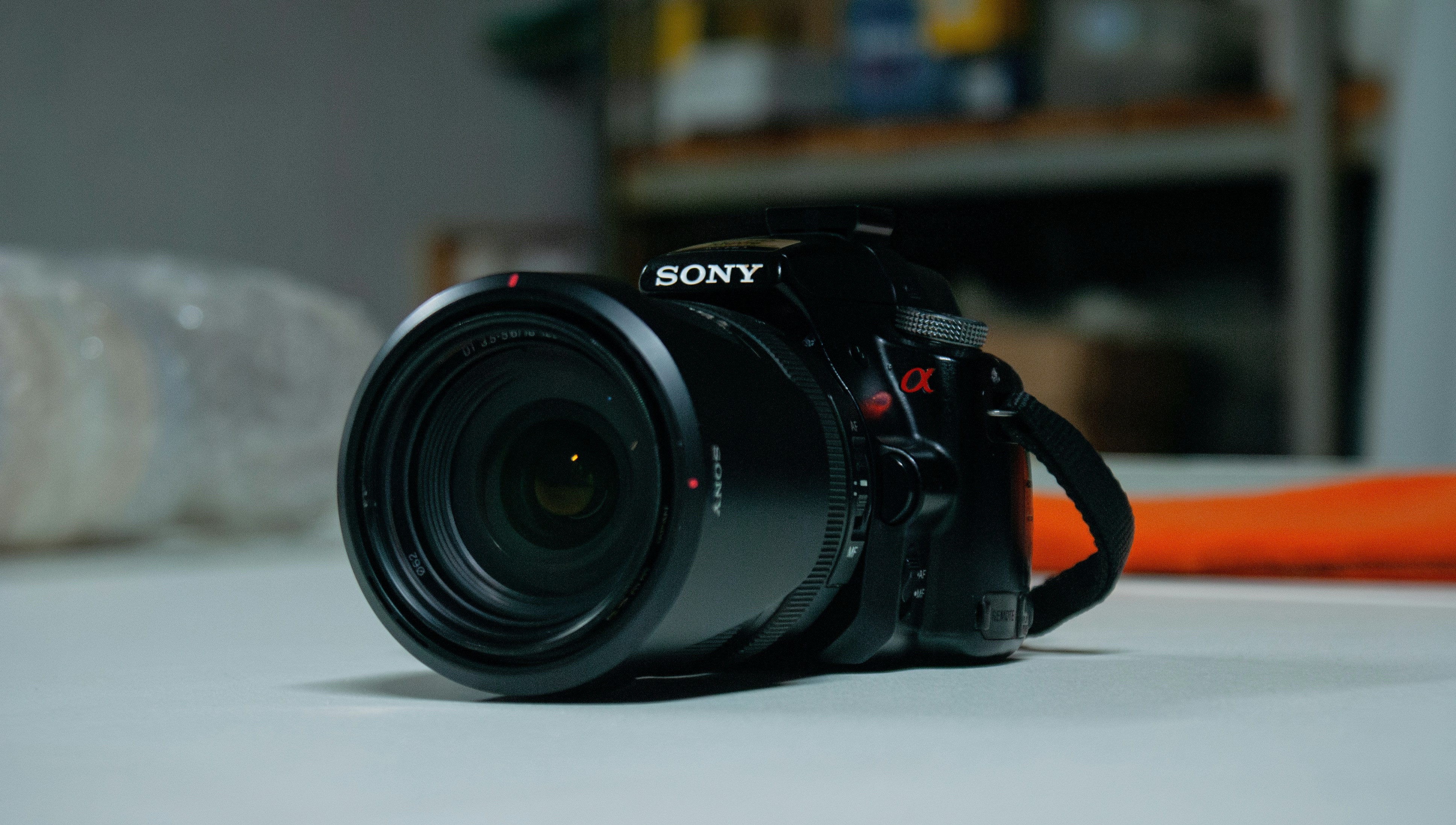 A camera sitting on top of a table next to a carrot photo – Free Lens ...