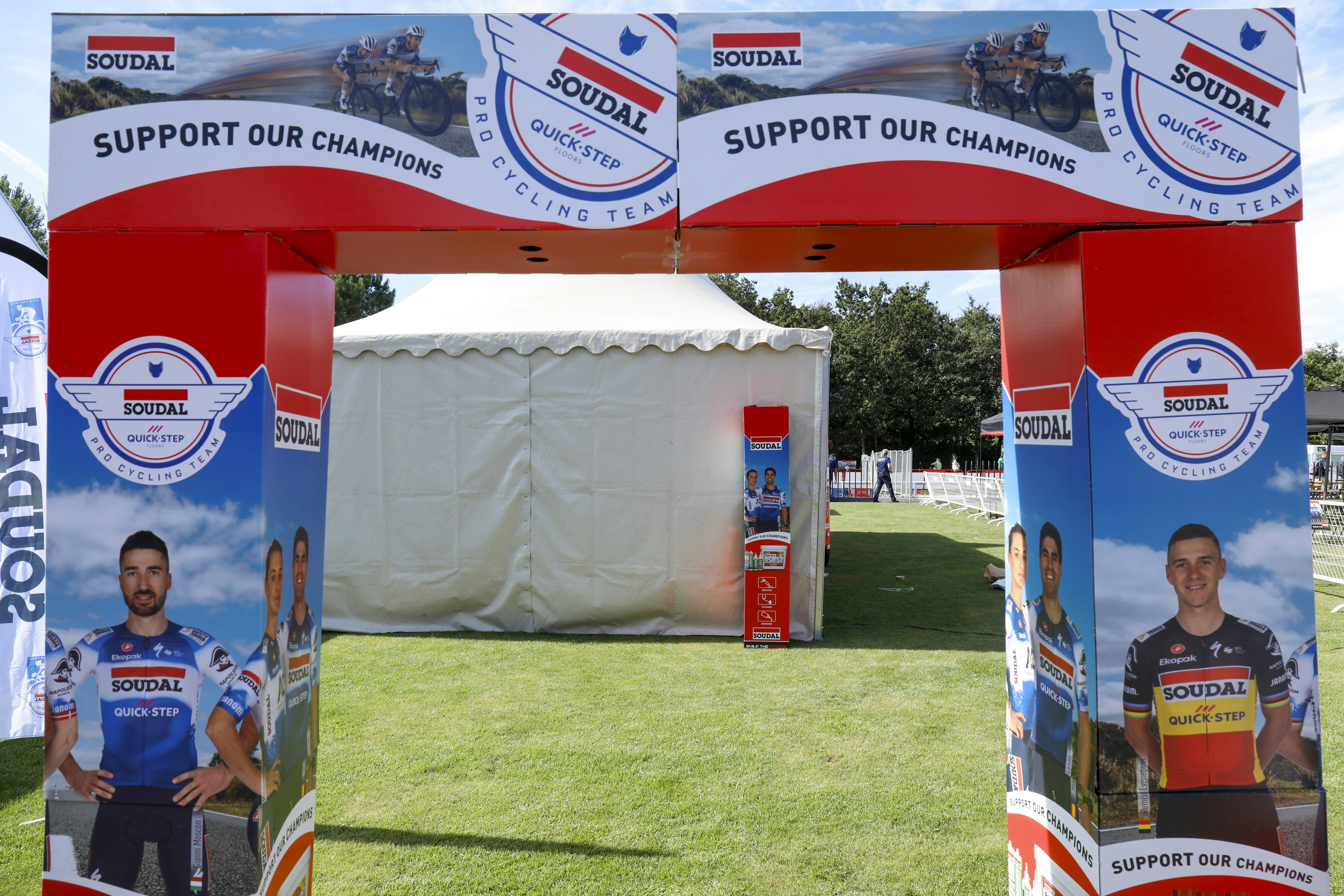 Archway of Champions: Sunlit Soudal Entrance Framing a Central Tent