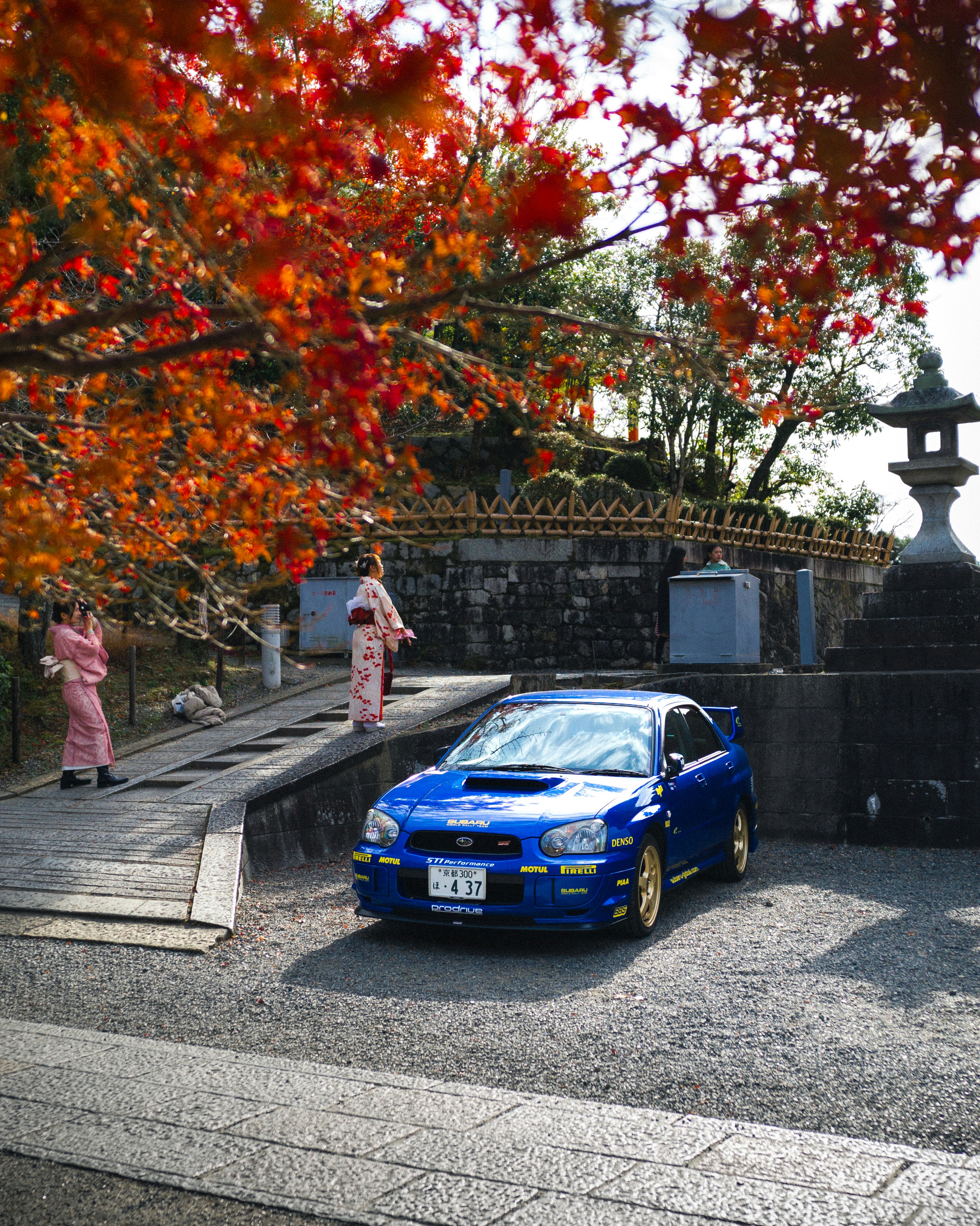 A blue car parked in front of a buildingJun Hong Tan
