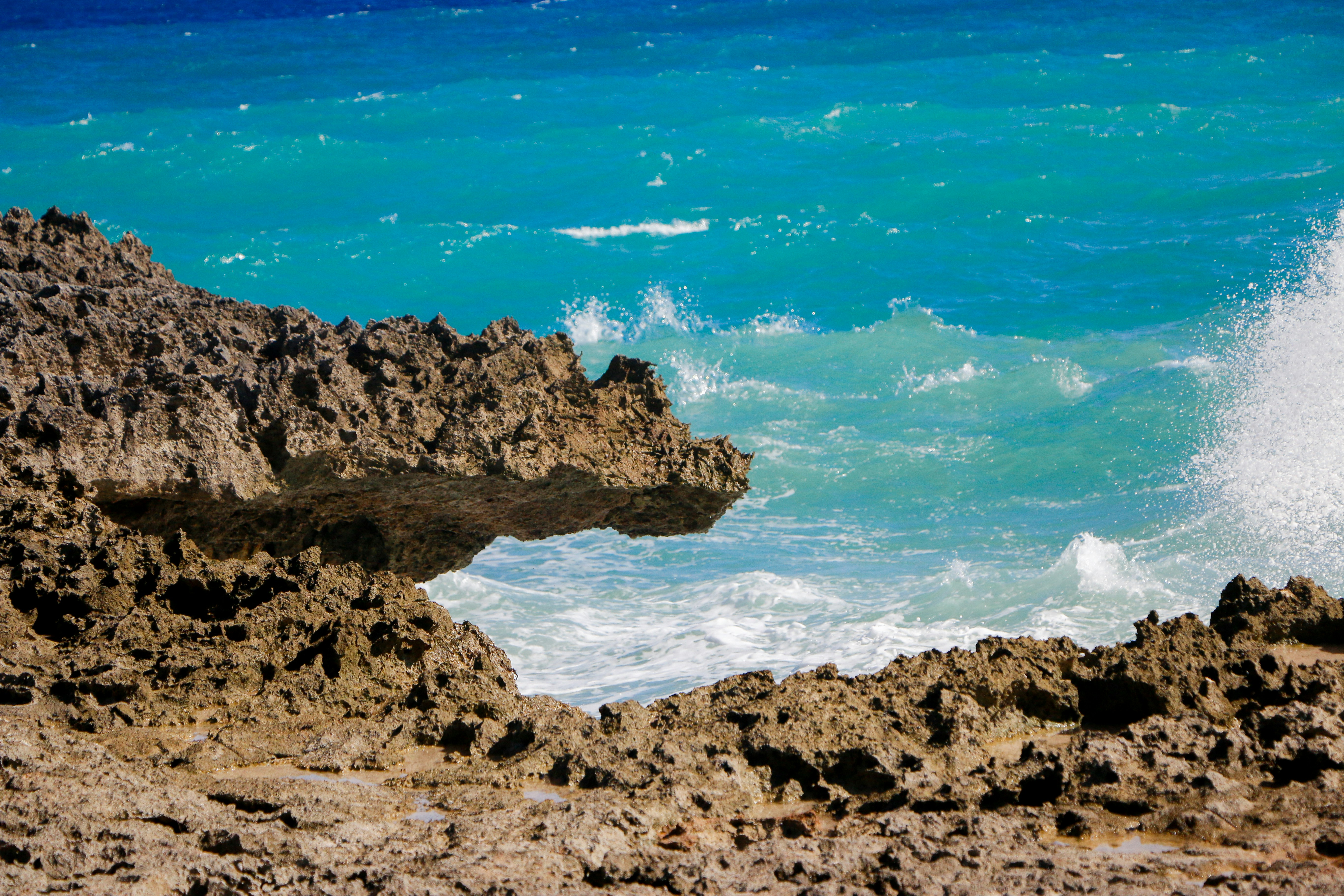 A wave crashes into the rocks at the beach photo – Free Dominican ...