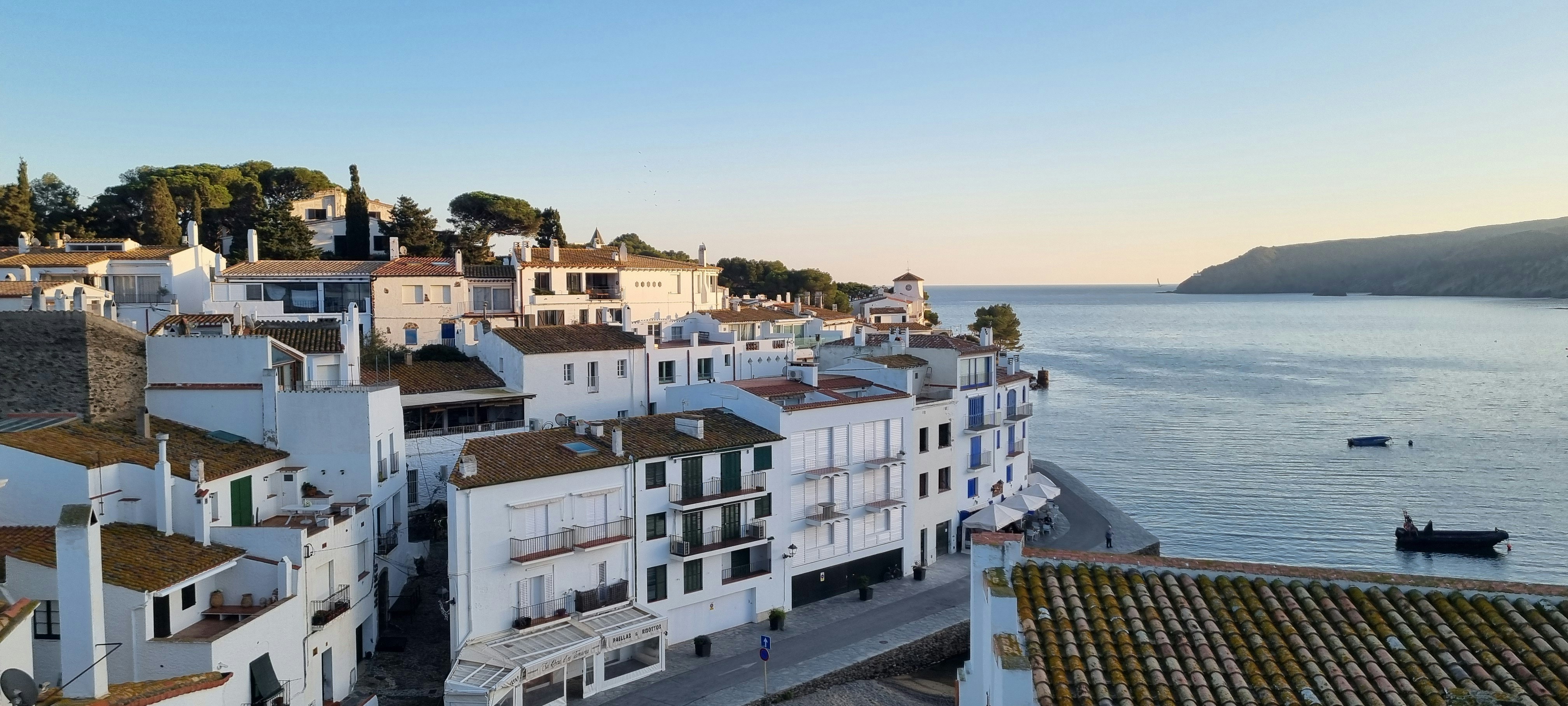 Sunlit Whitewashed Harbor Village Clinging to the Sea
