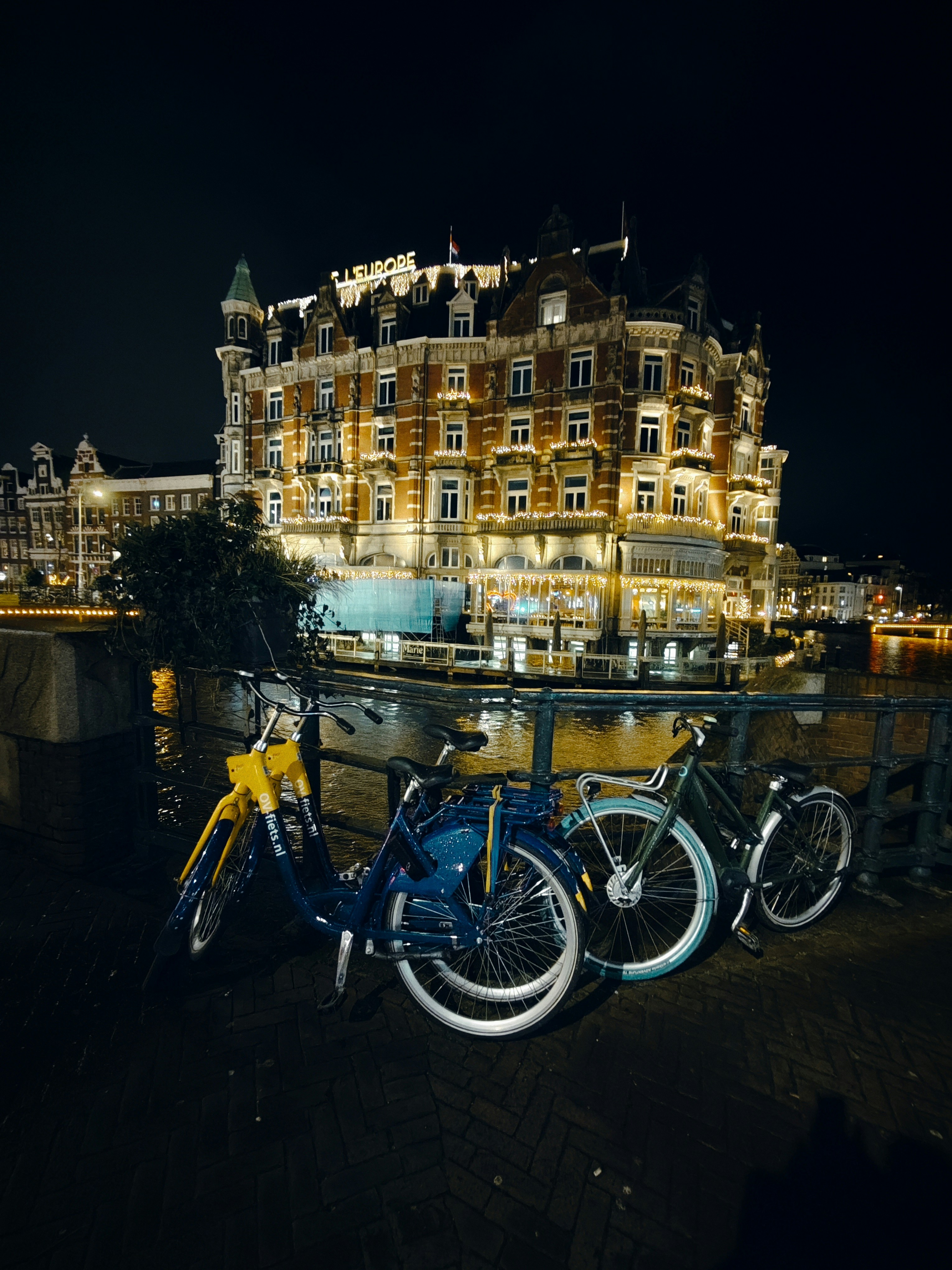 Night by the Quays: Bicycles in the Glow of a Grand Waterfront Hotel
