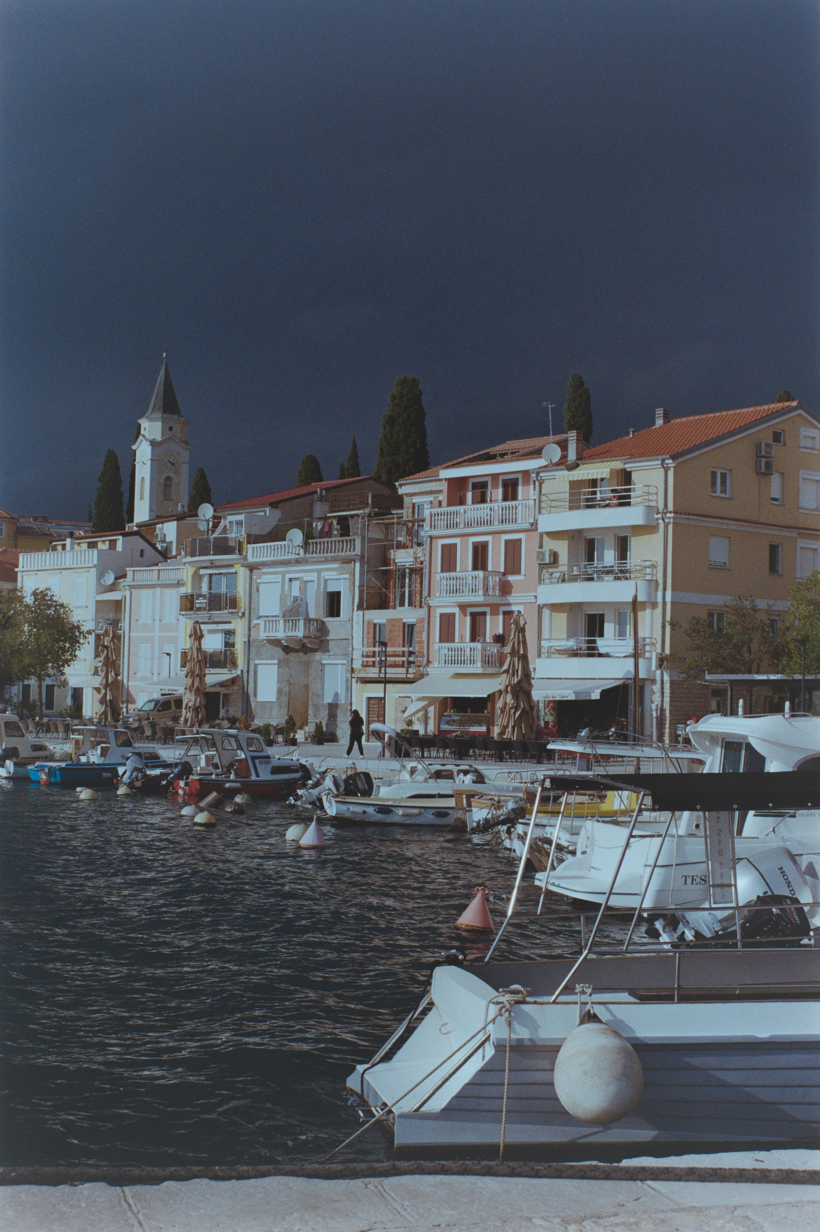 Dusk over the Harborfront: pastel façades, boats, and a lone church spire