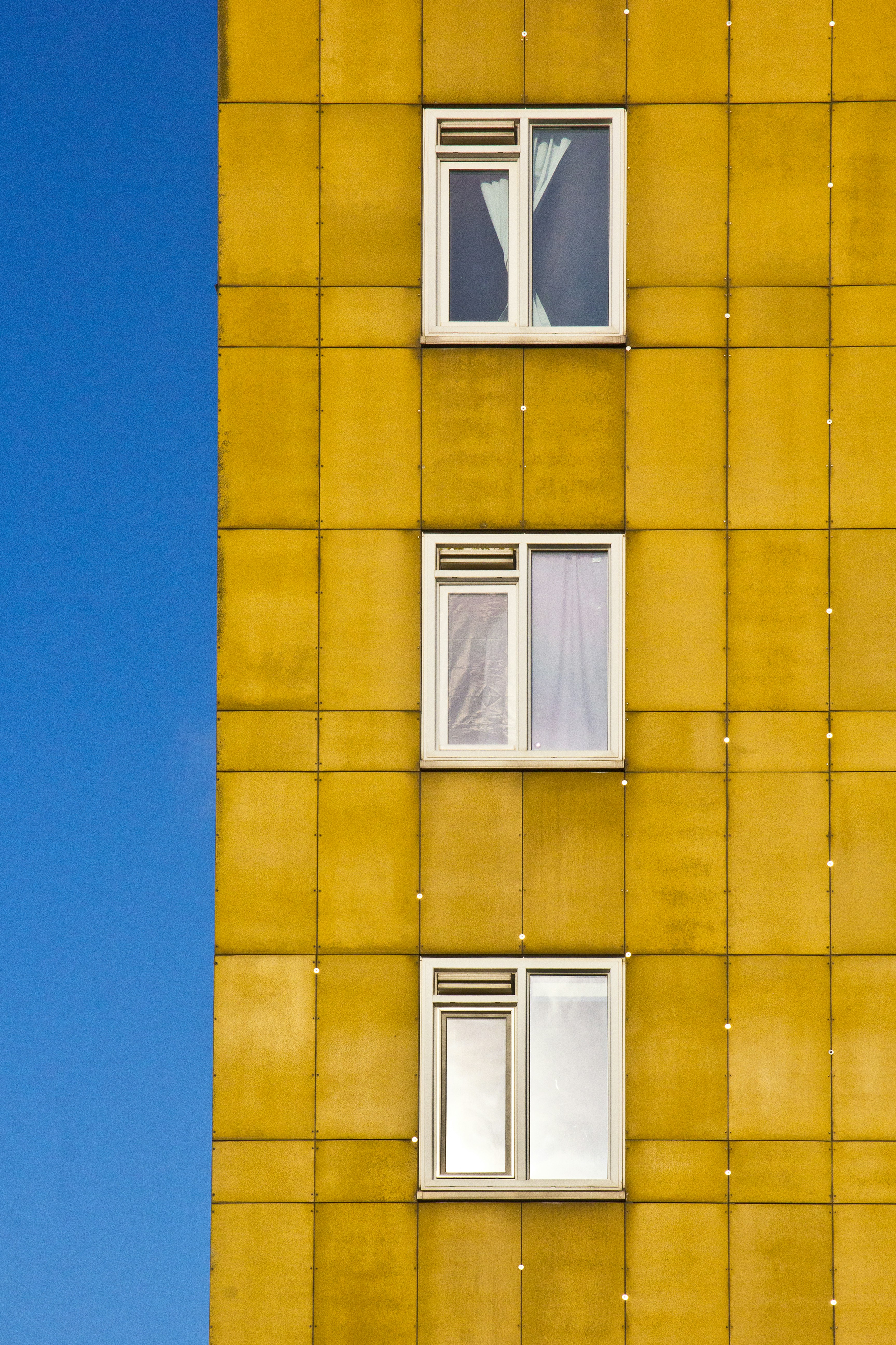 A tall yellow building with three windows photo – Free Enschede Image ...