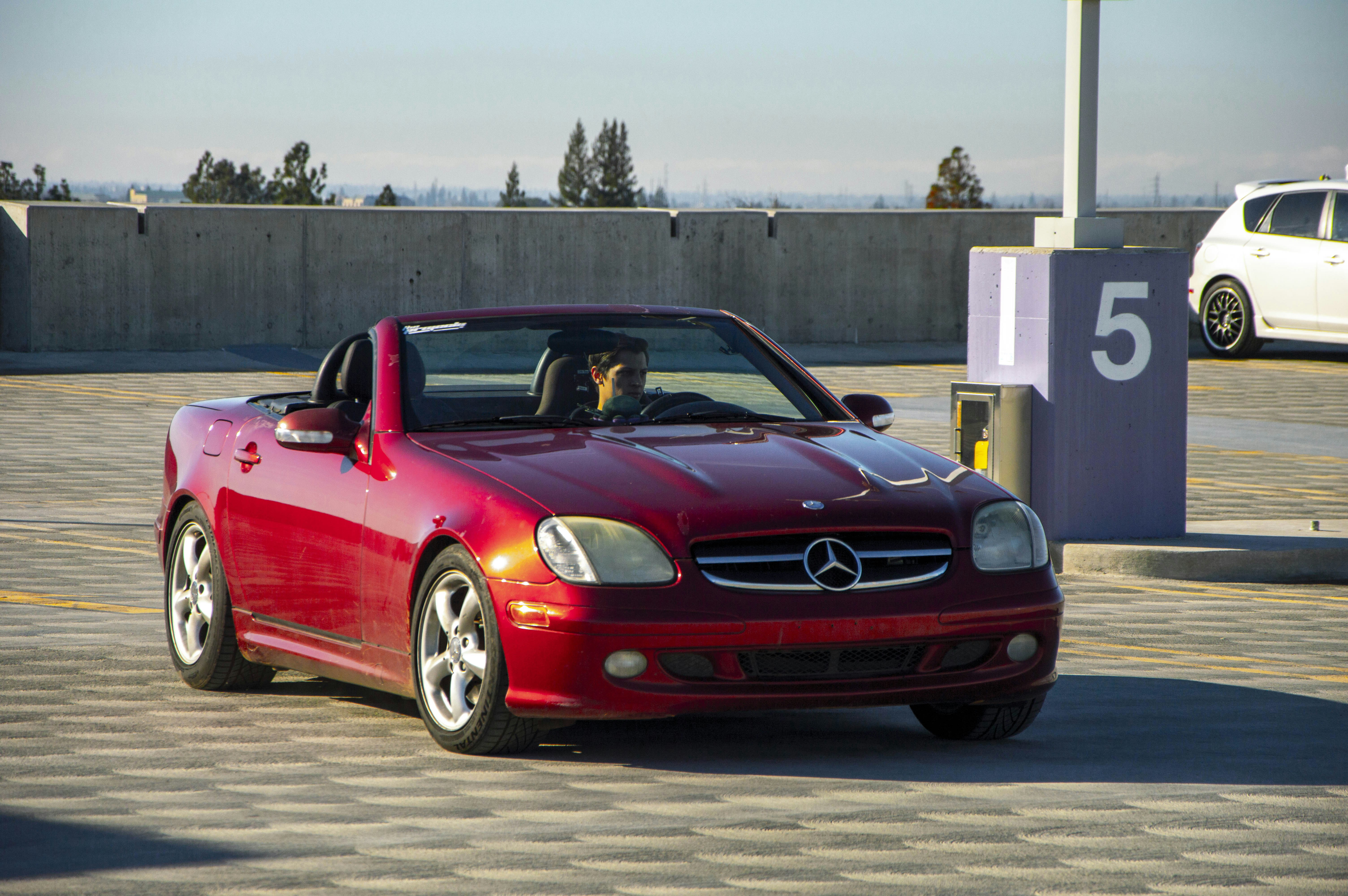 A red convertible car parked in a parking lot photo – Free Automobile ...