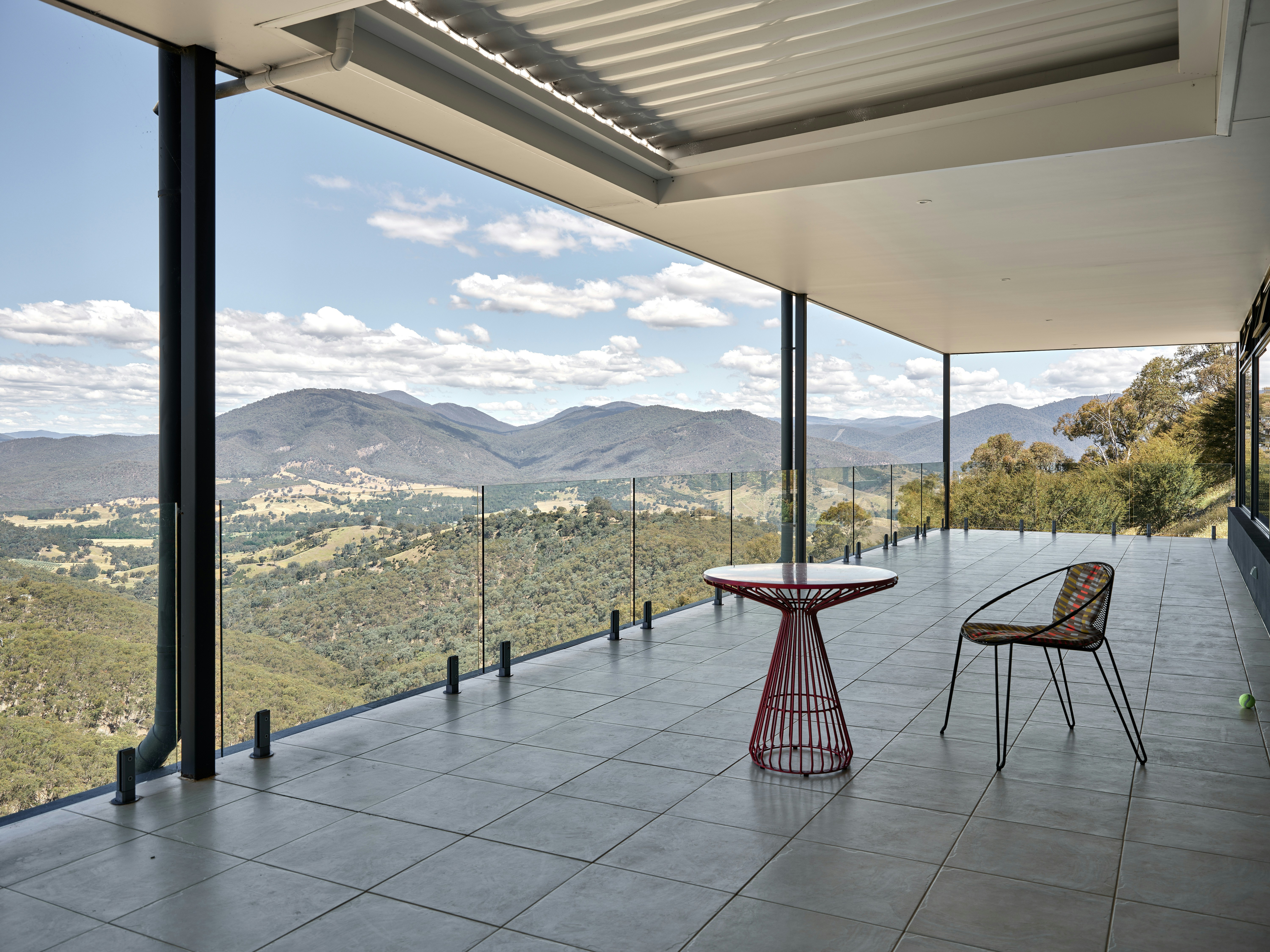 A patio with a table and chairs overlooking mountains photo – Free ...