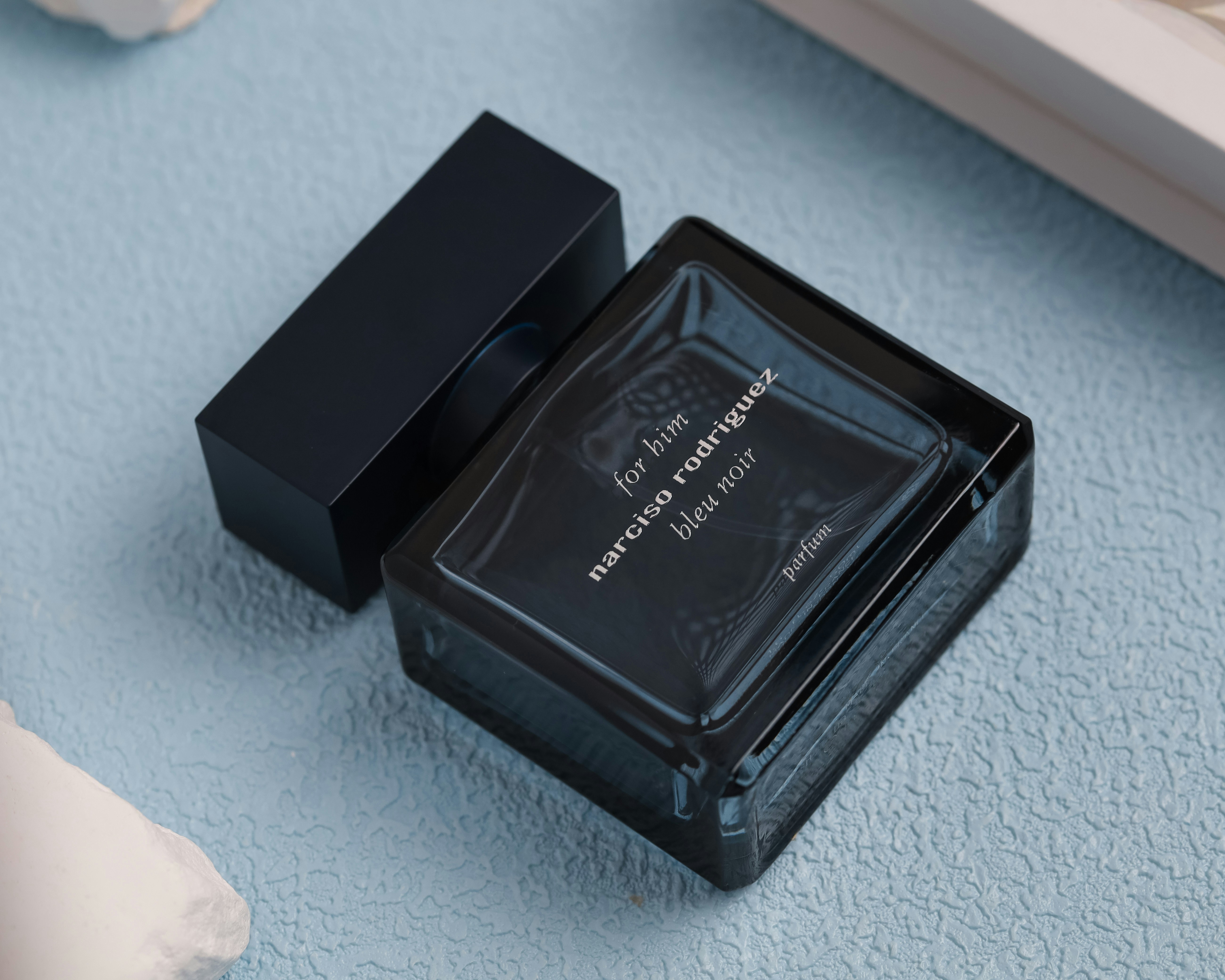 A black square container sitting on top of a blue surface photo – Free ...