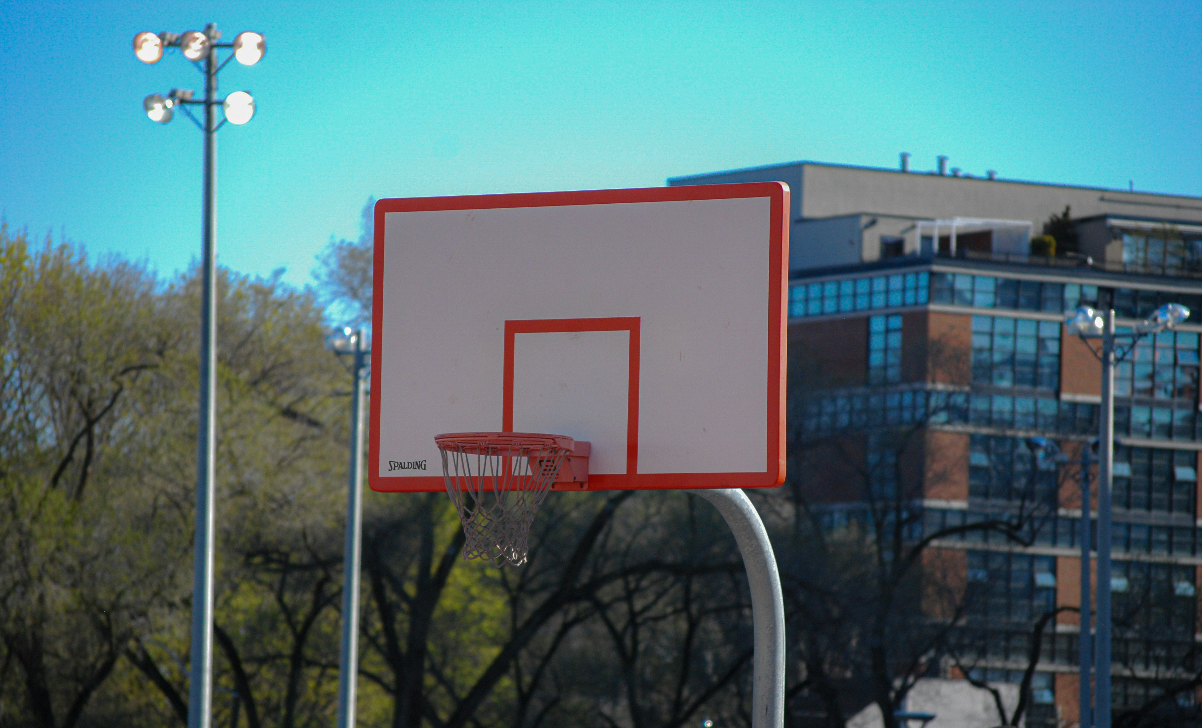 A basketball hoop in front of a tall building photo – Free Basketball ...