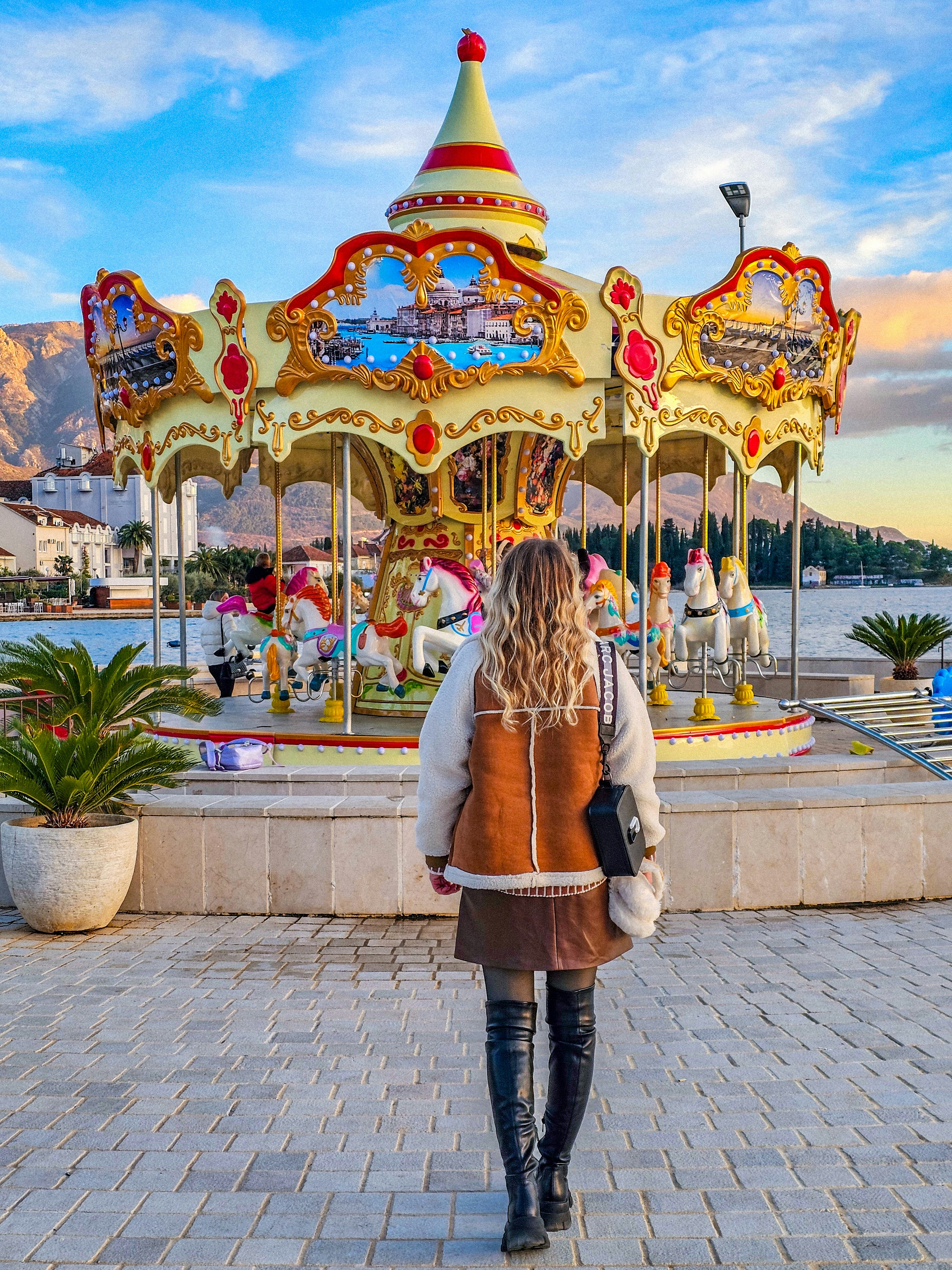 Harbor Carousel at Dusk: A Traveler Before Golden Horses