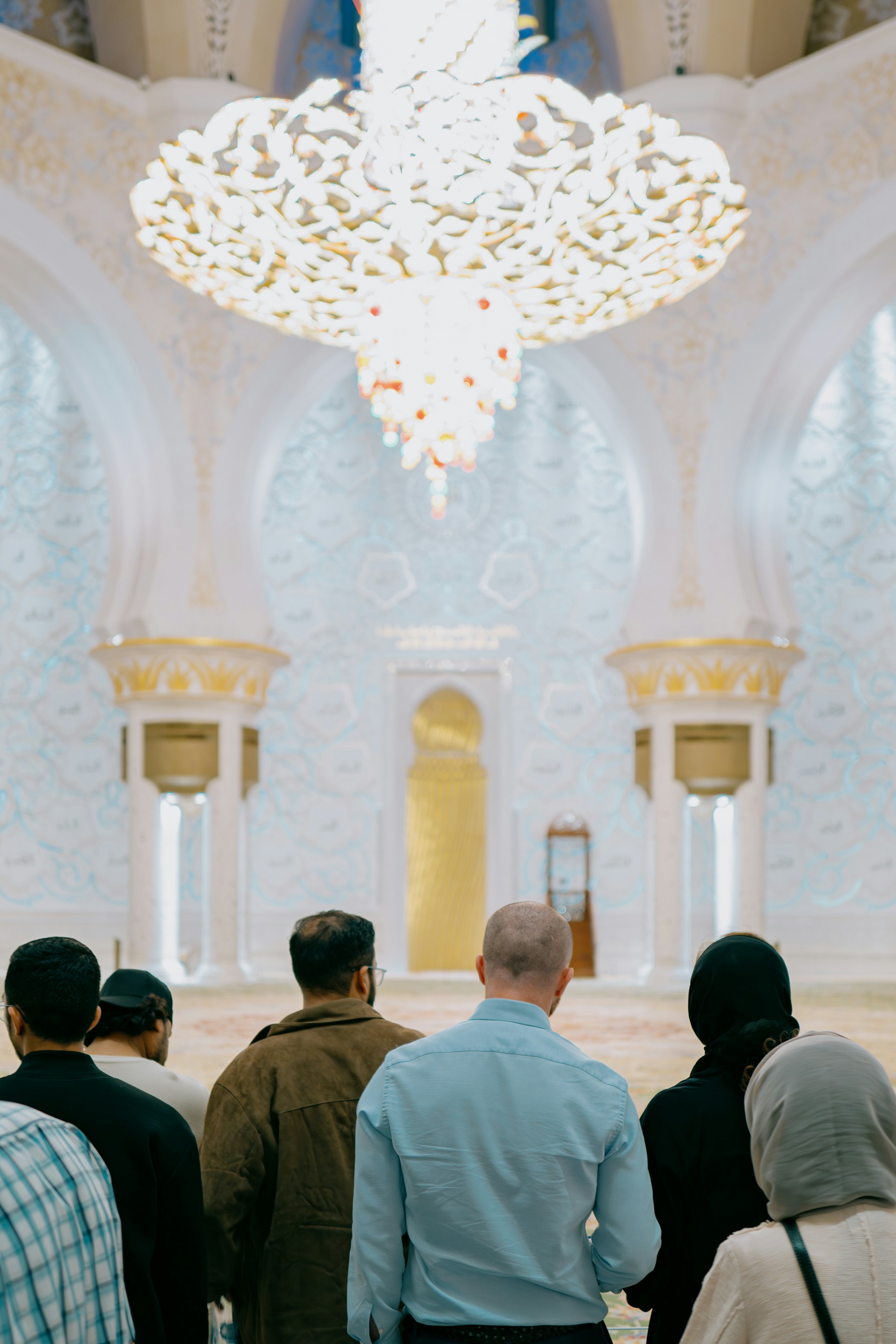 A group of people standing in front of a chandelier photo – Free ...
