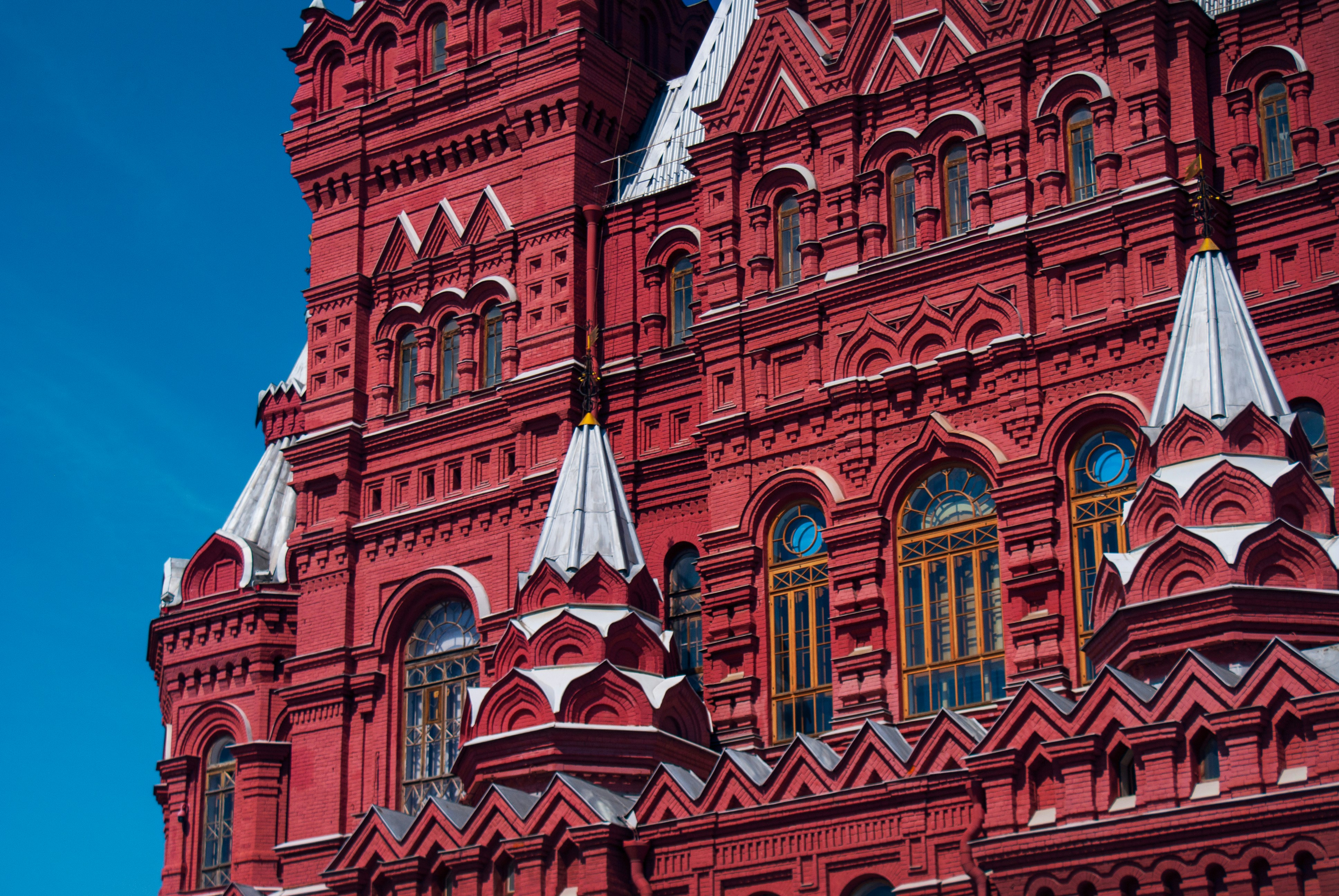 A large red building with a clock on it's side photo – Free Wallpaper ...