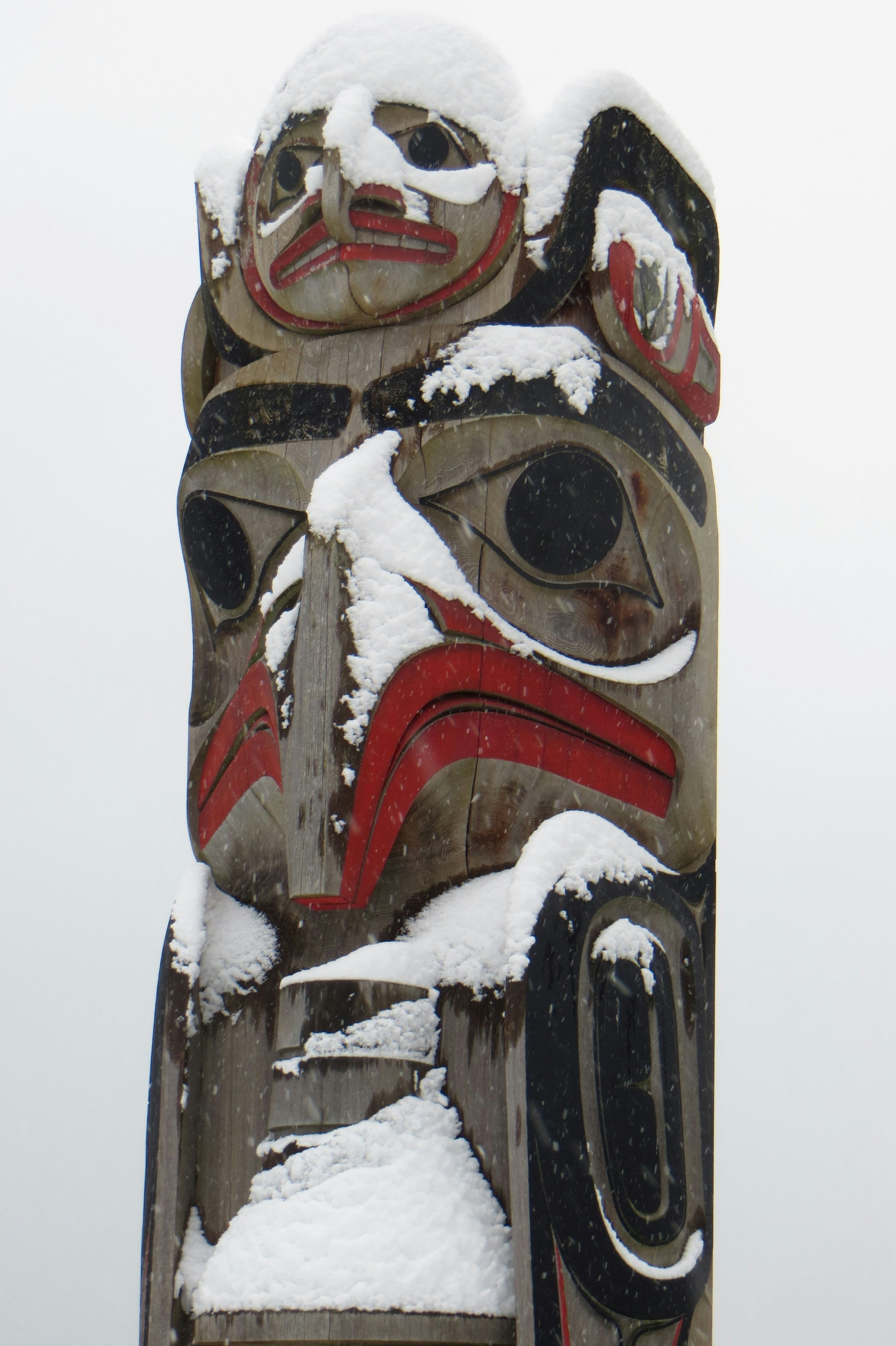 A totema is covered in snow on a pole photo – Free White rock Image on ...