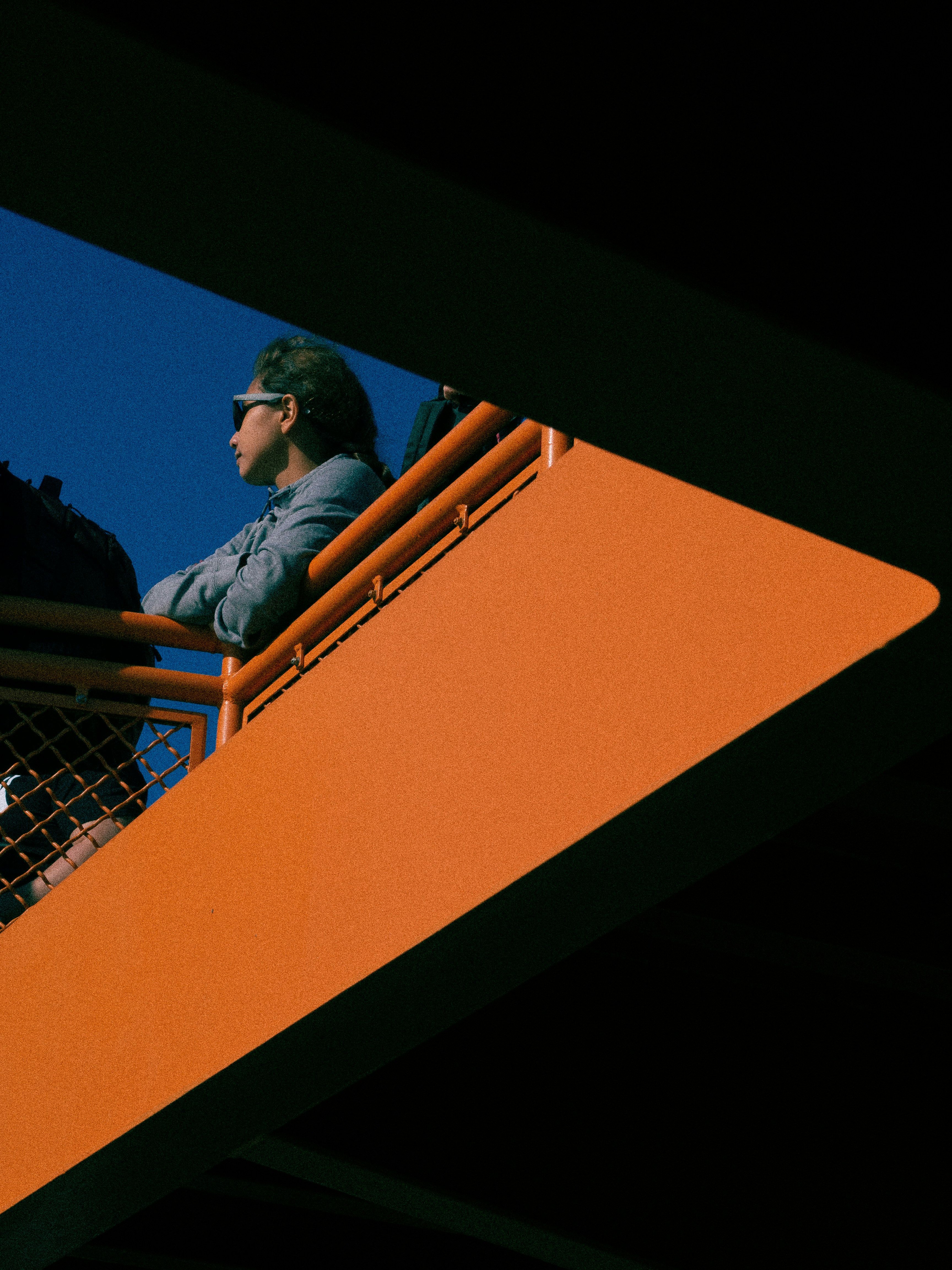 Railing Observer: A Quiet Moment Above the Blue
