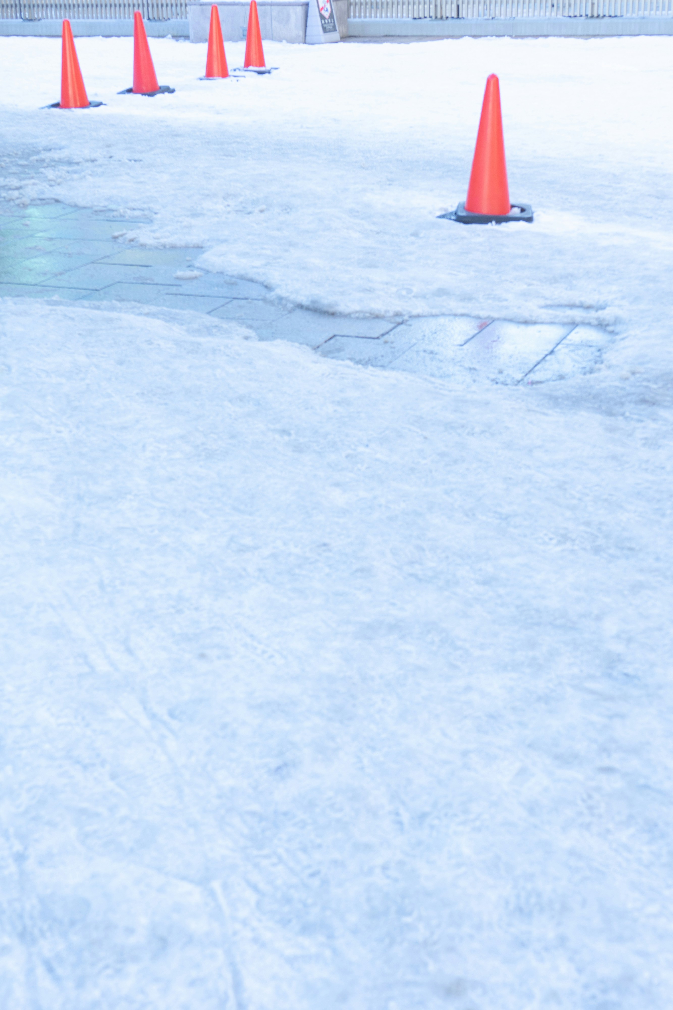 Orange Beacons Line a Blue-White Snow Street