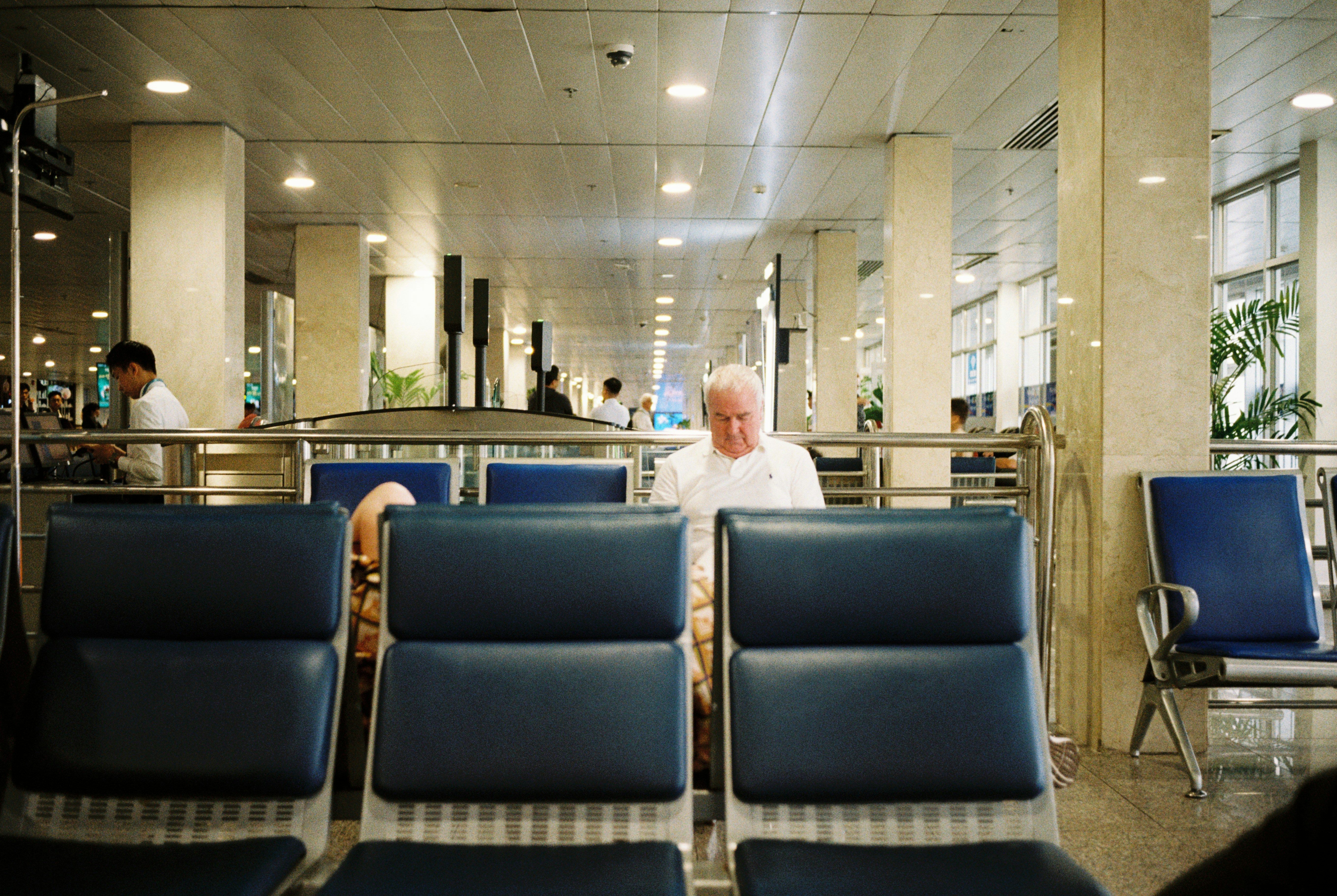 A man sitting in a waiting area of an airport