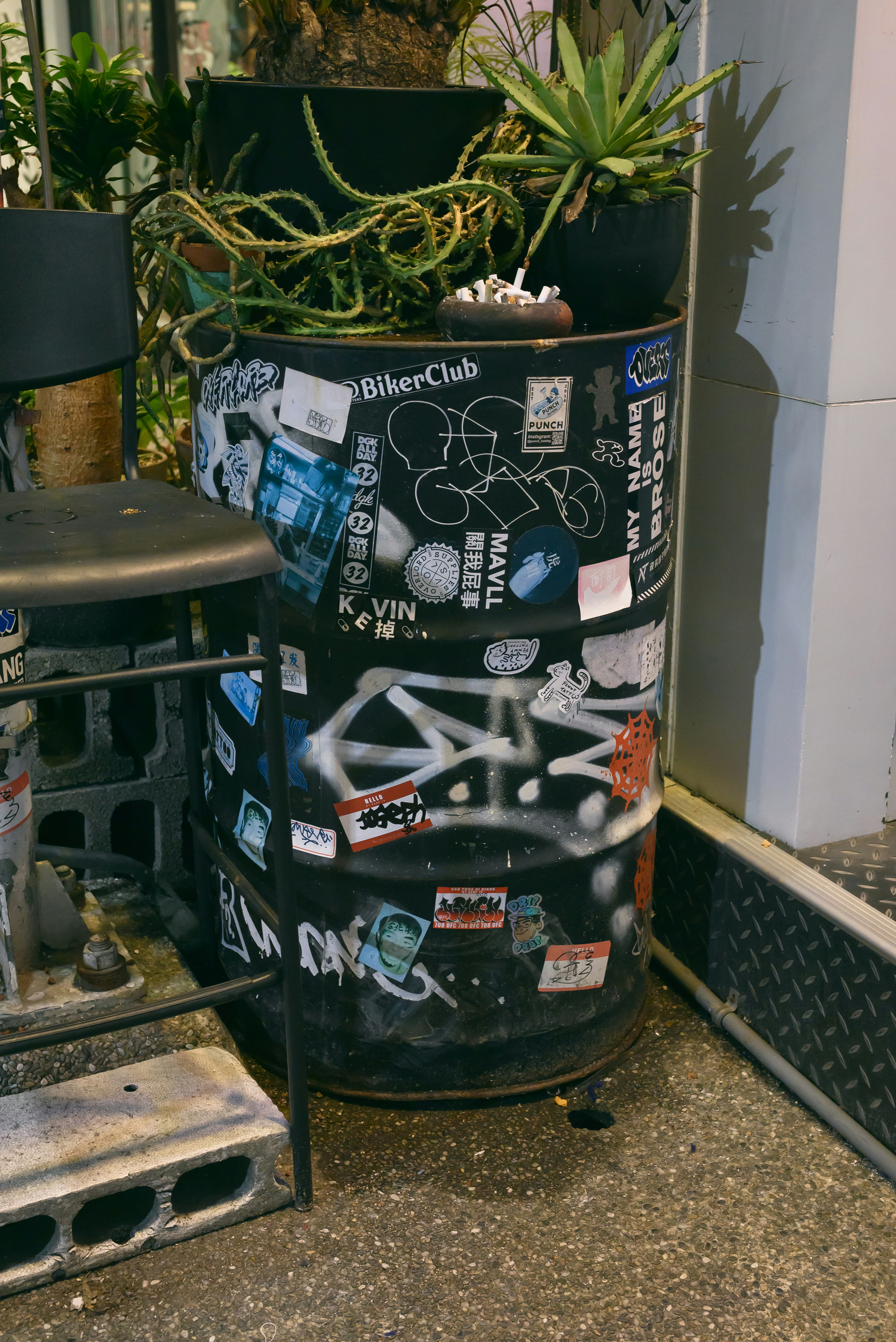 A trash can covered in stickers next to a chair photo – Free Human ...